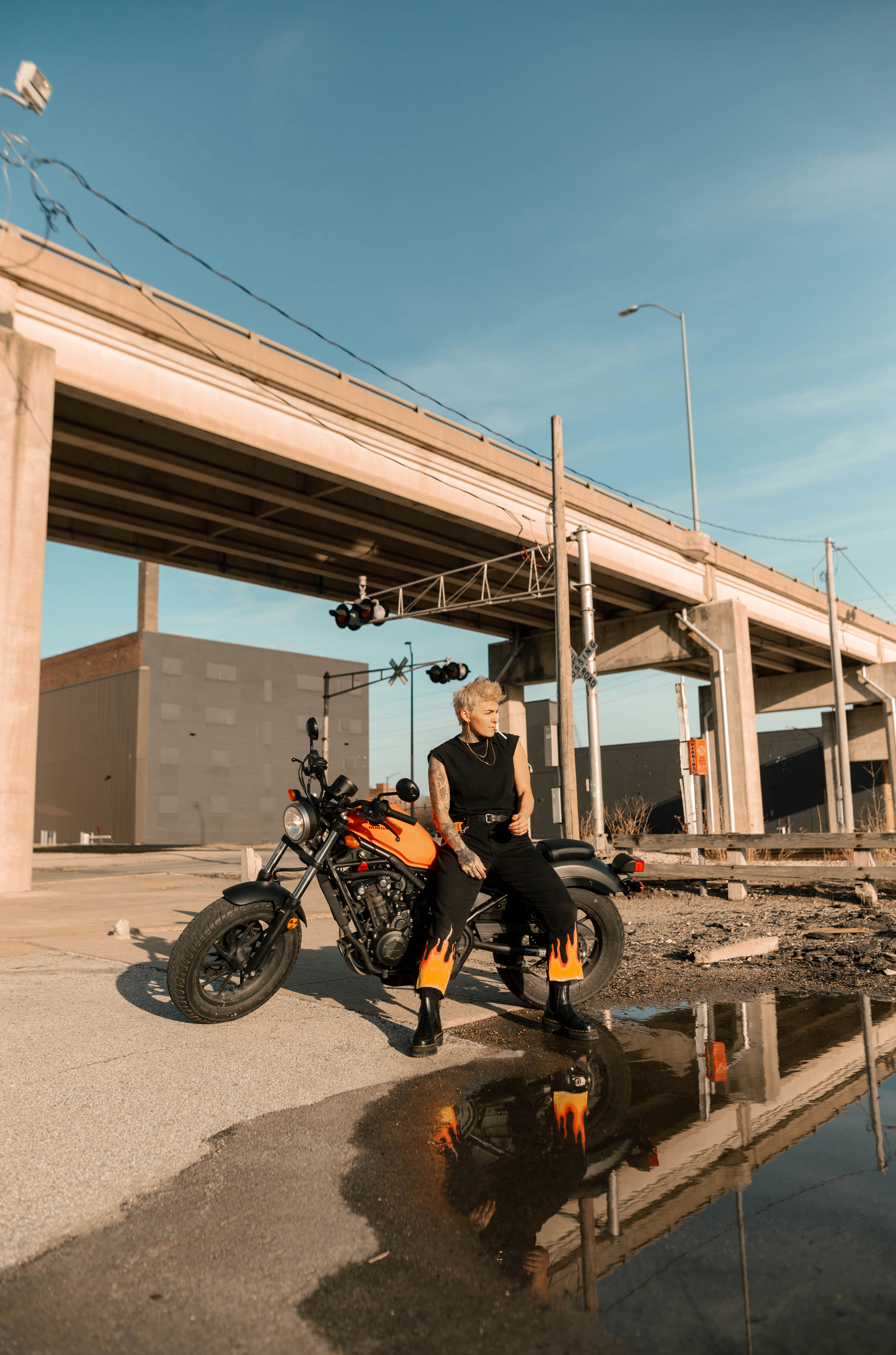 Underpass Stance: Portrait of a Rider beside a Flame-Orange Motorcycle