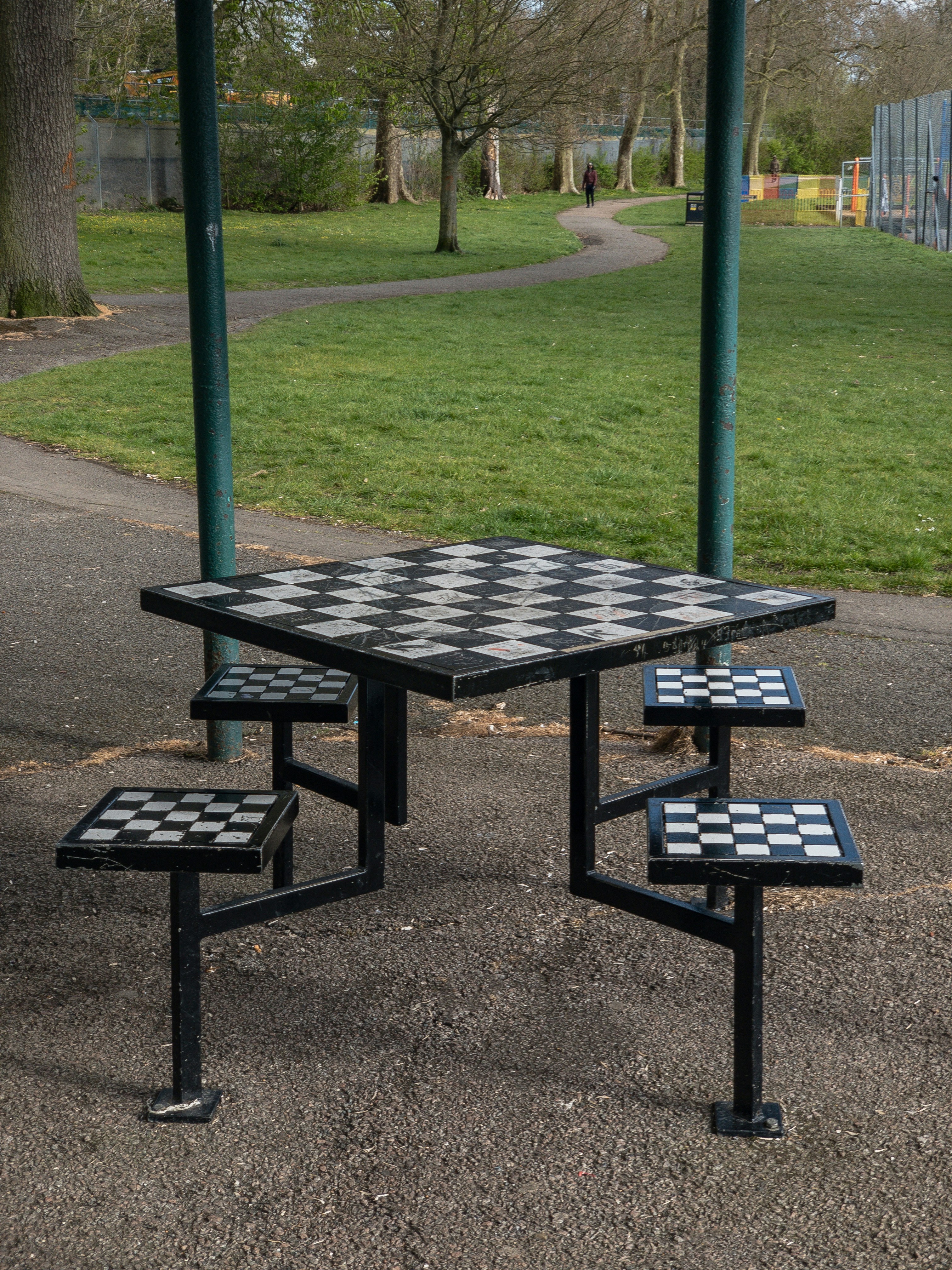 Checkerboard Picnic Table Framing a Serene Park Walkway