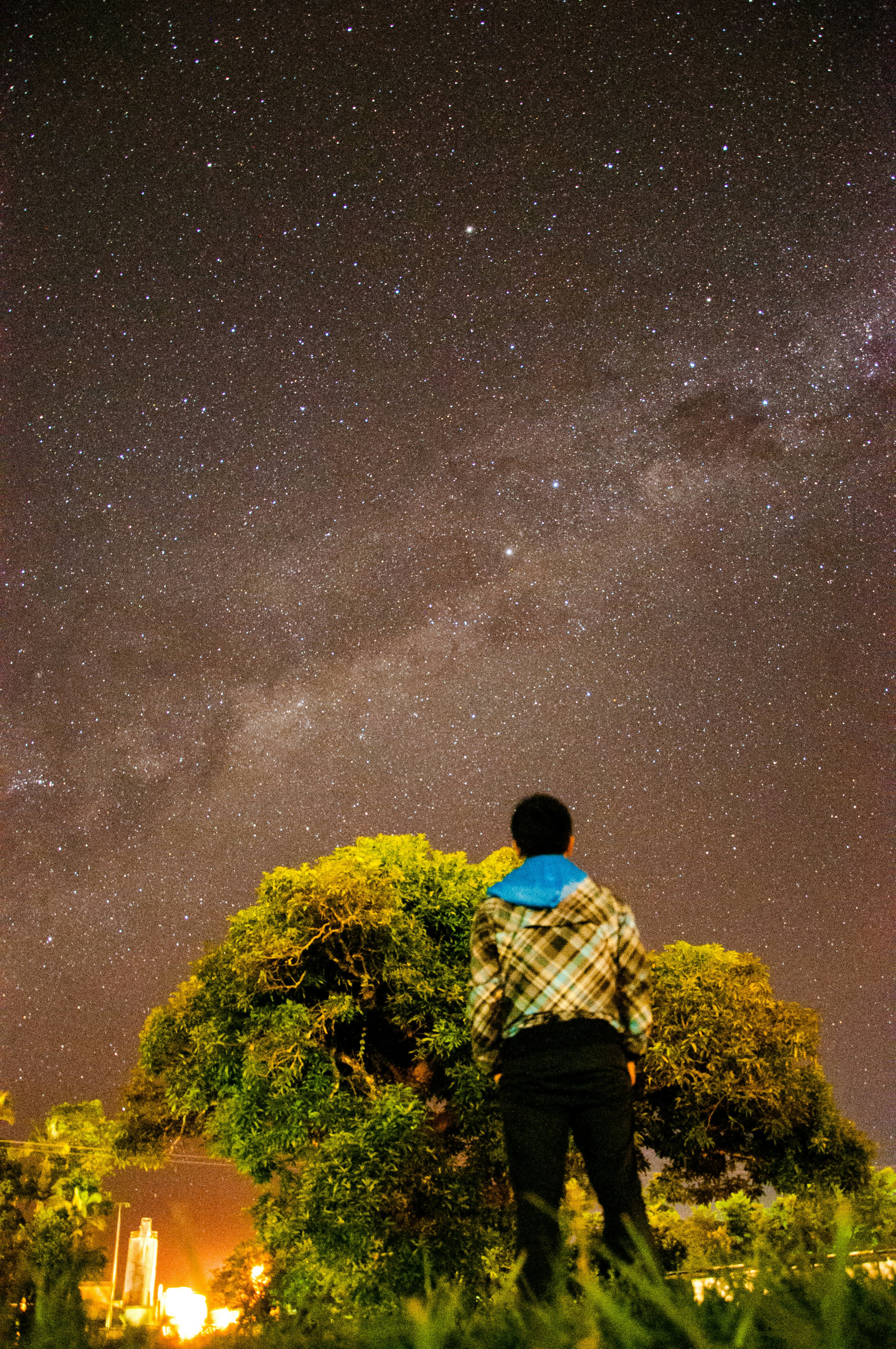 Lone Silhouette Beneath a Milky Way Arch Over a Quiet Town