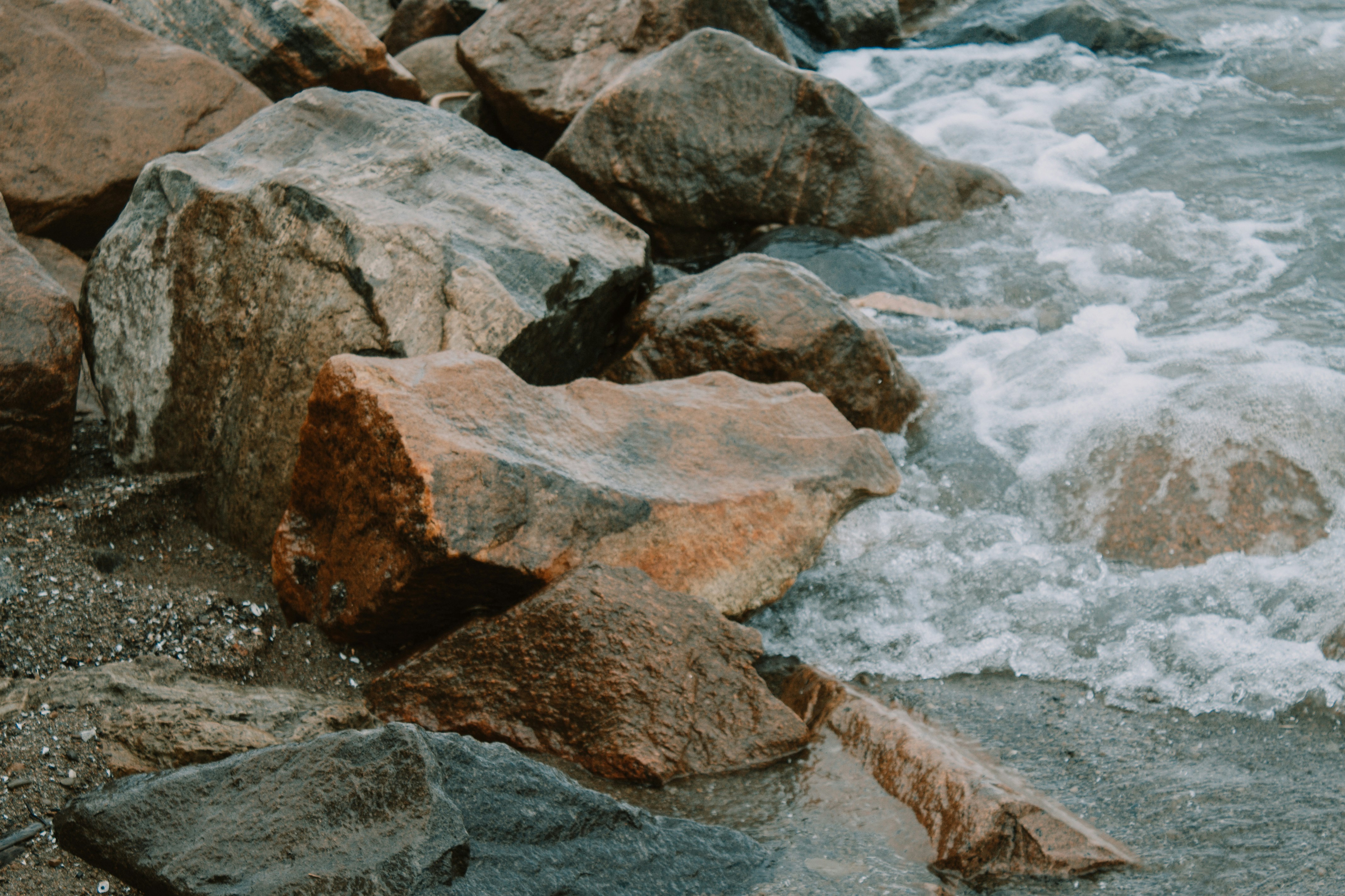 A group of rocks by a body of water photo – Free Stone Image on Unsplash
