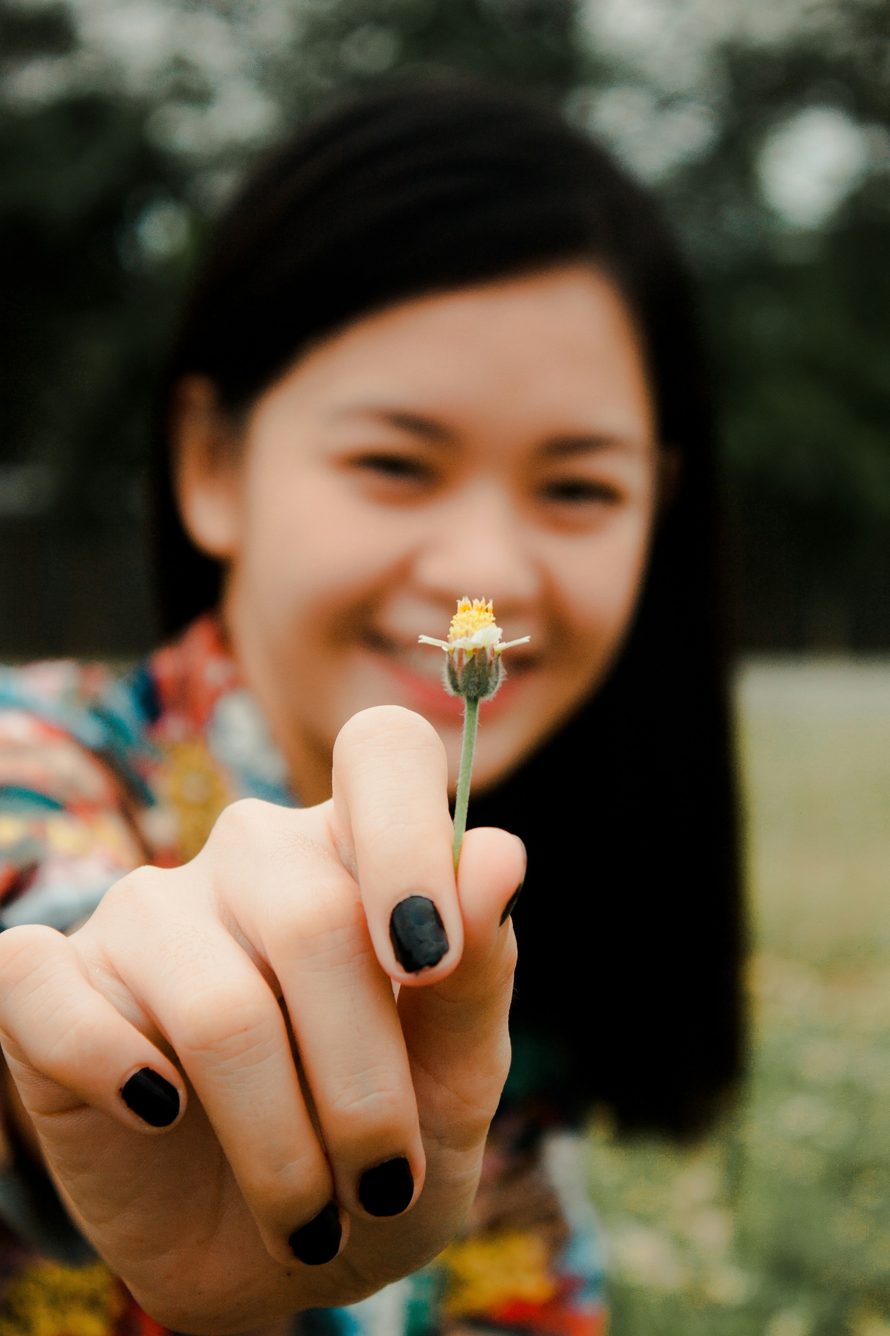 Delicate Foreground: A Daisy Presented Before a Soft-Focused Smile