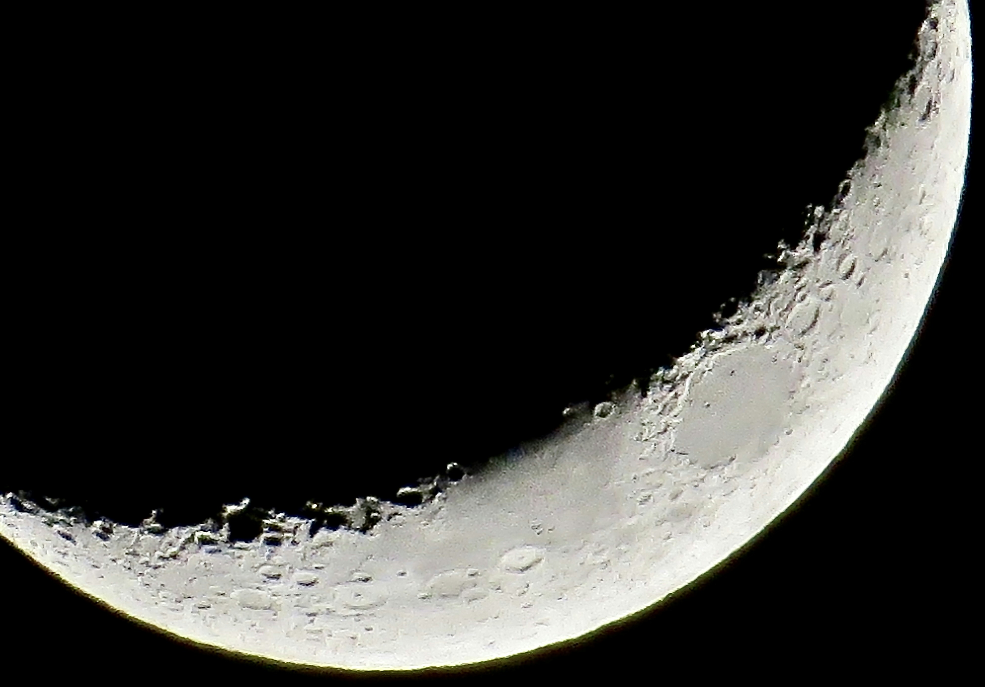 Crescent Moon's Cratered Edge in Sharp Focus