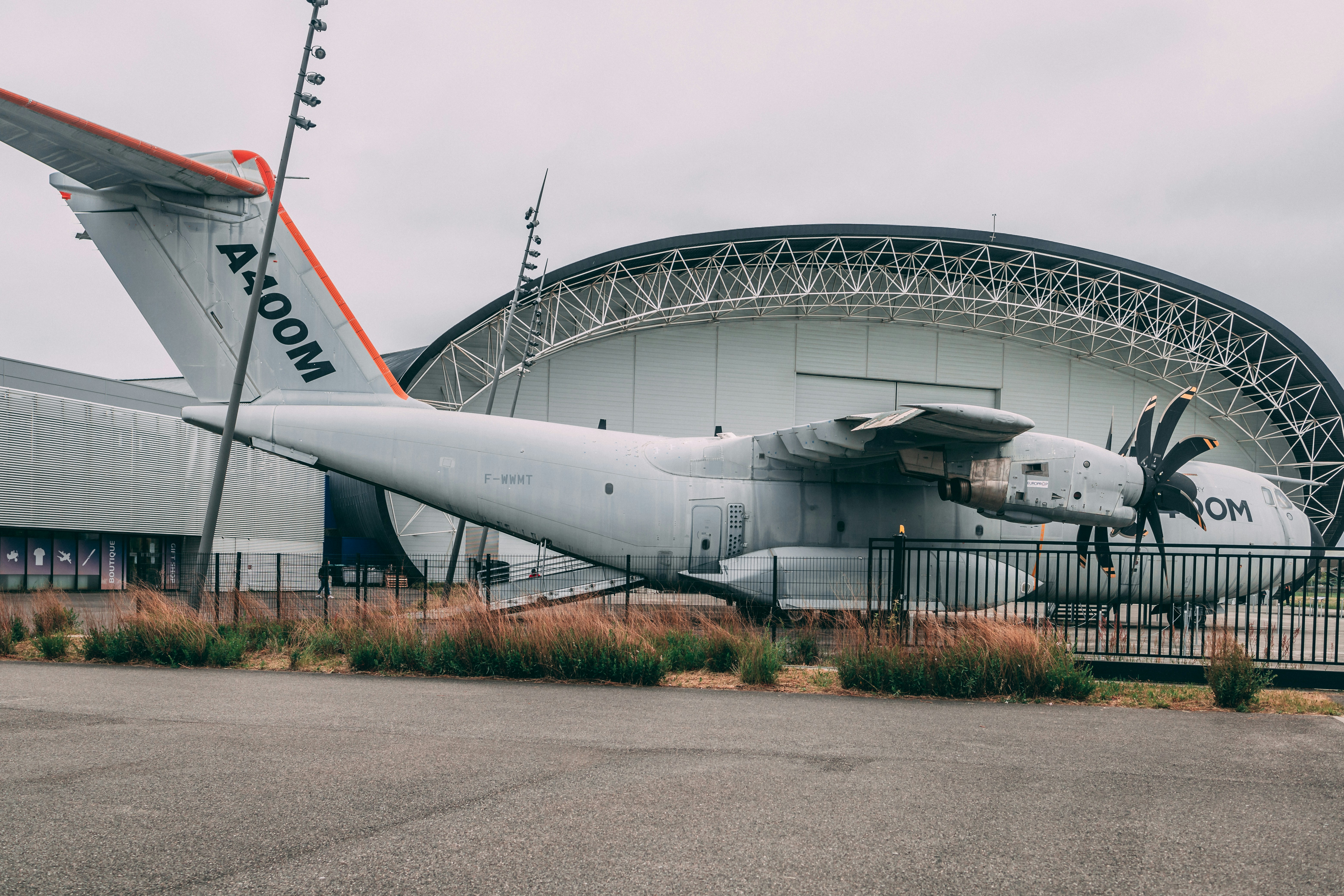 Propeller Relic by a Modern Hangar: A Vintage Aircraft at Rest