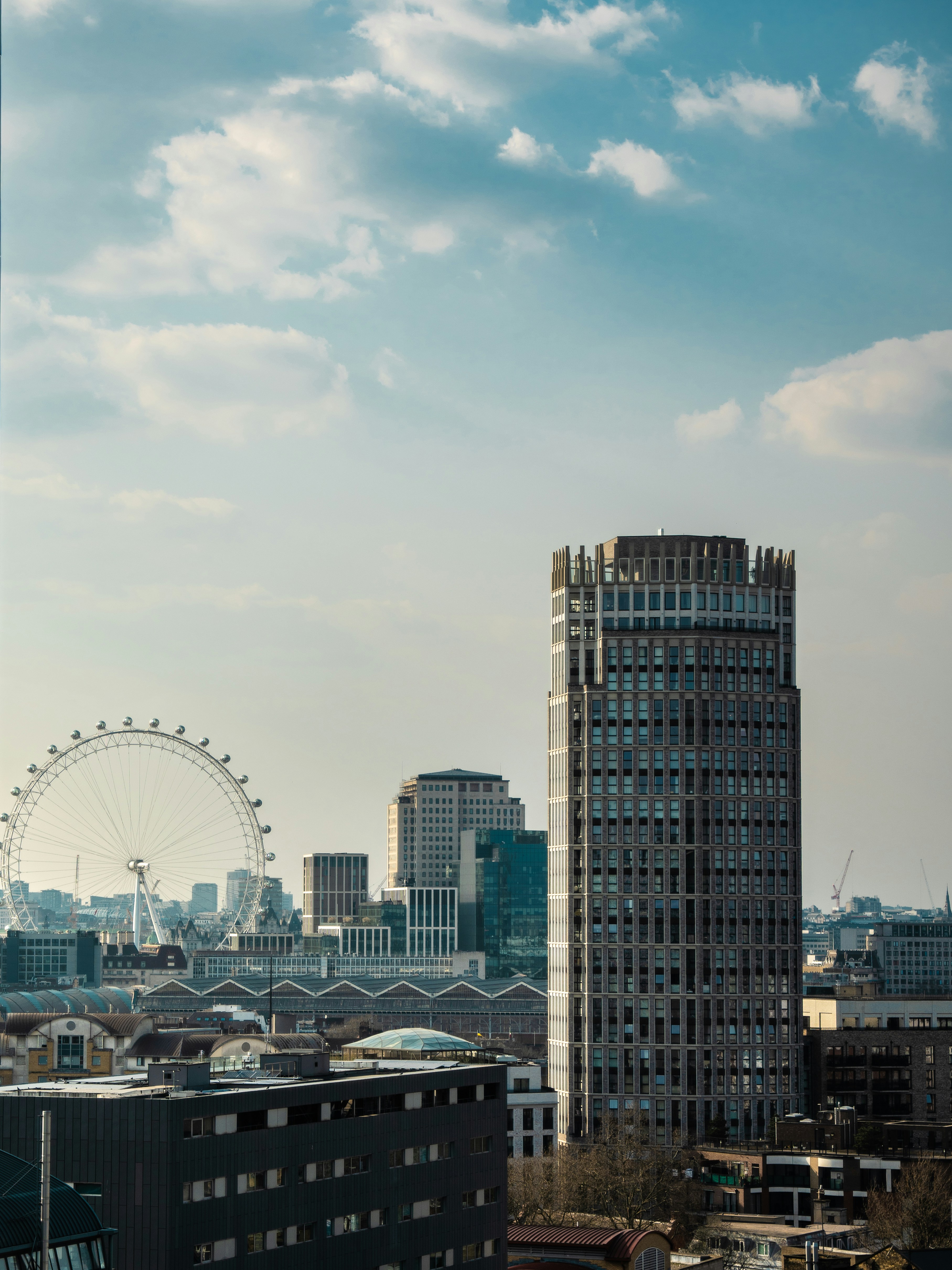 Towered Quietude: A sunlit high-rise anchors a skyline with the London Eye in view