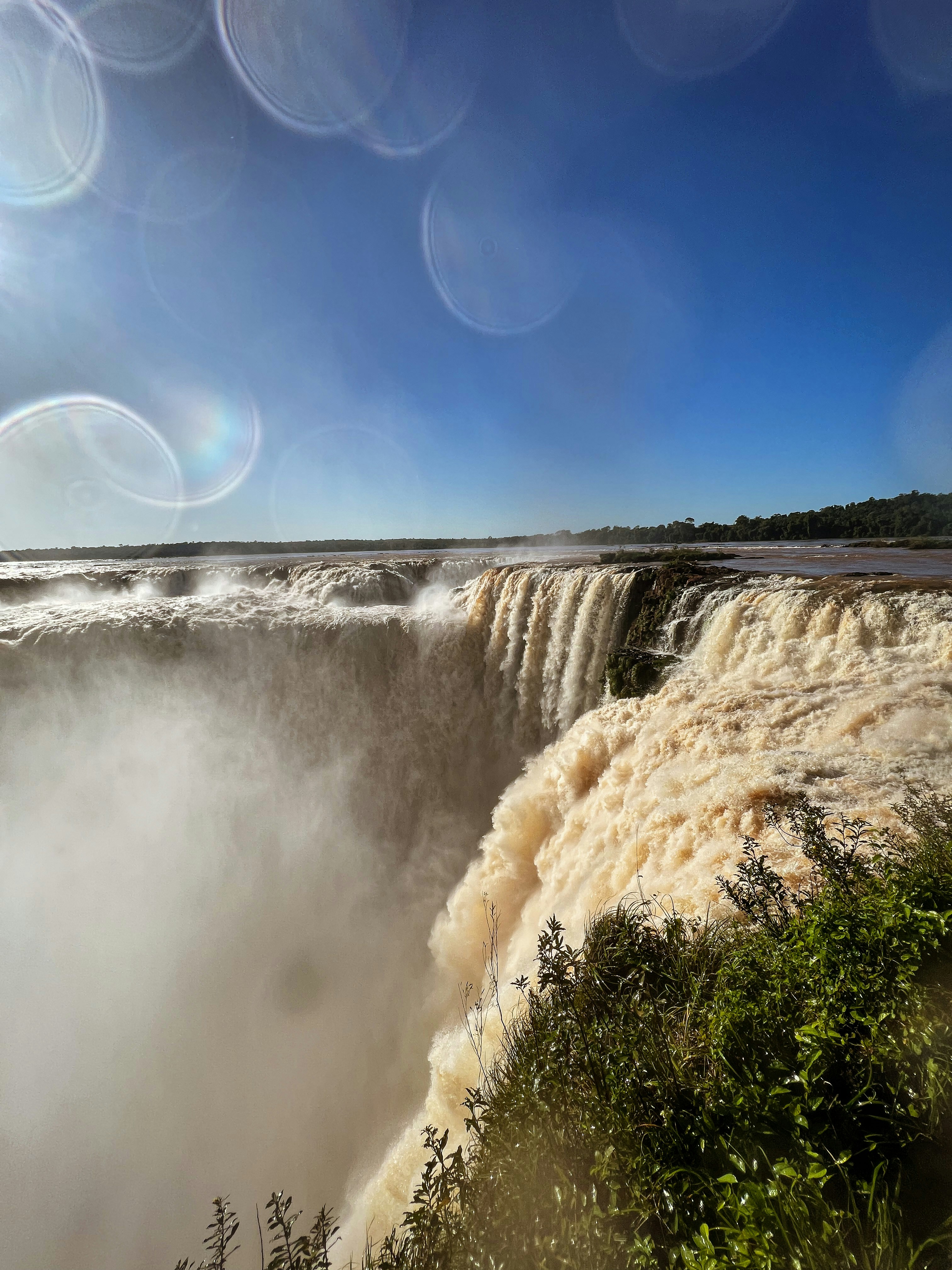 Cascading Dawn: A Wide Falls Scene with Lens Flares and Blue Skies