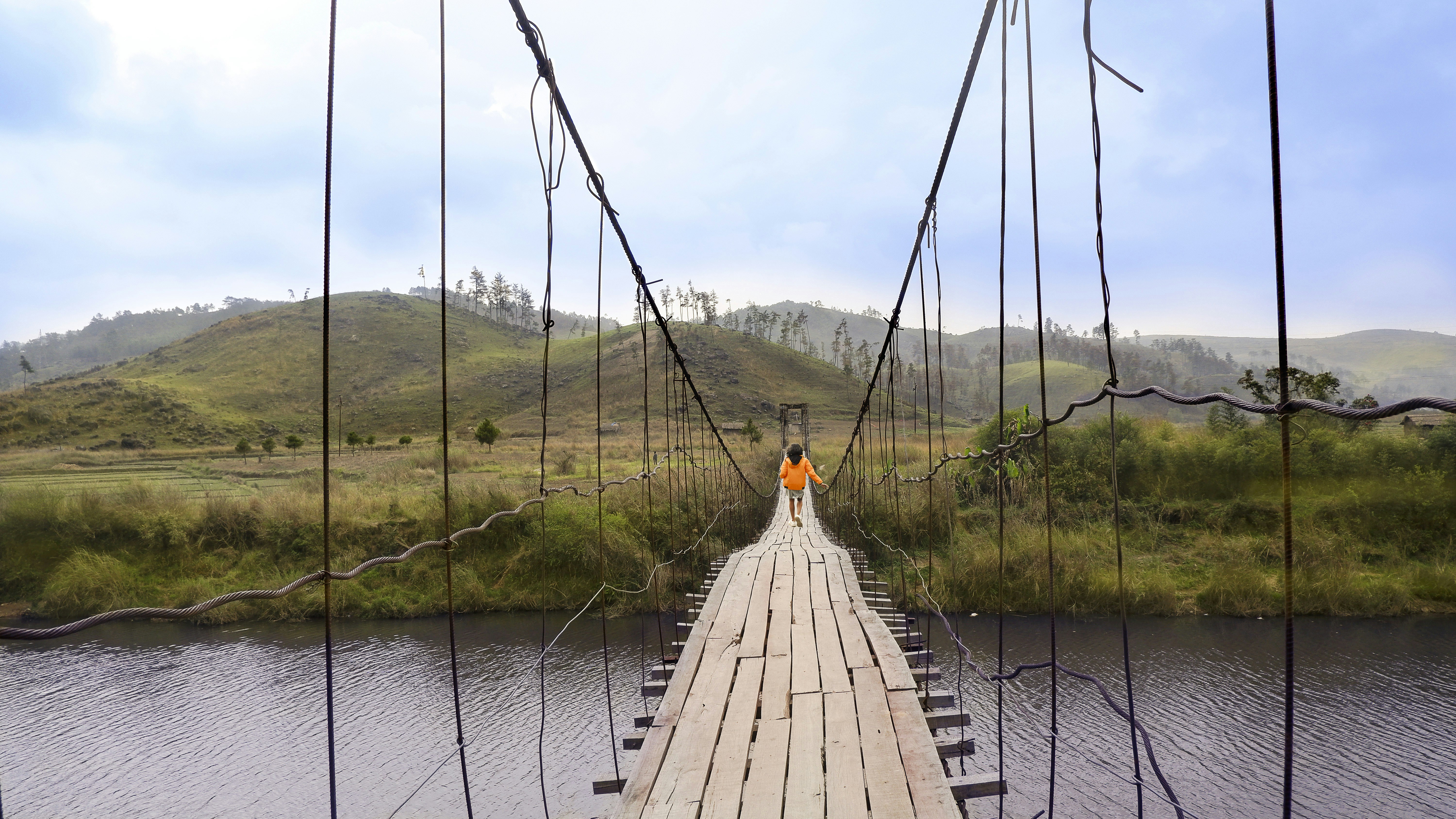 A person walking on a wooden bridge over water photo – Free India Image ...