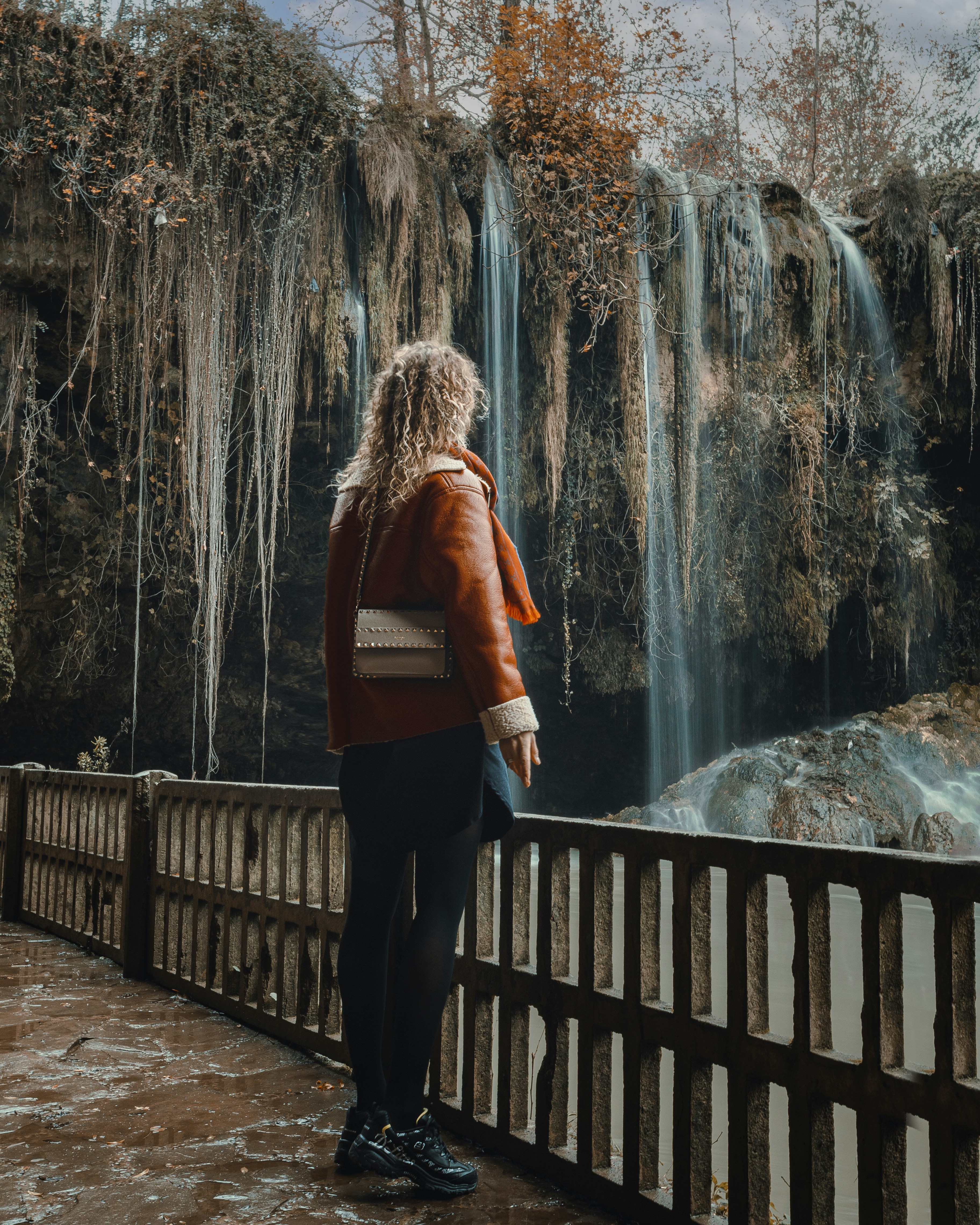 Rust Coat at the Edge: Quiet Contemplation by a Cascade