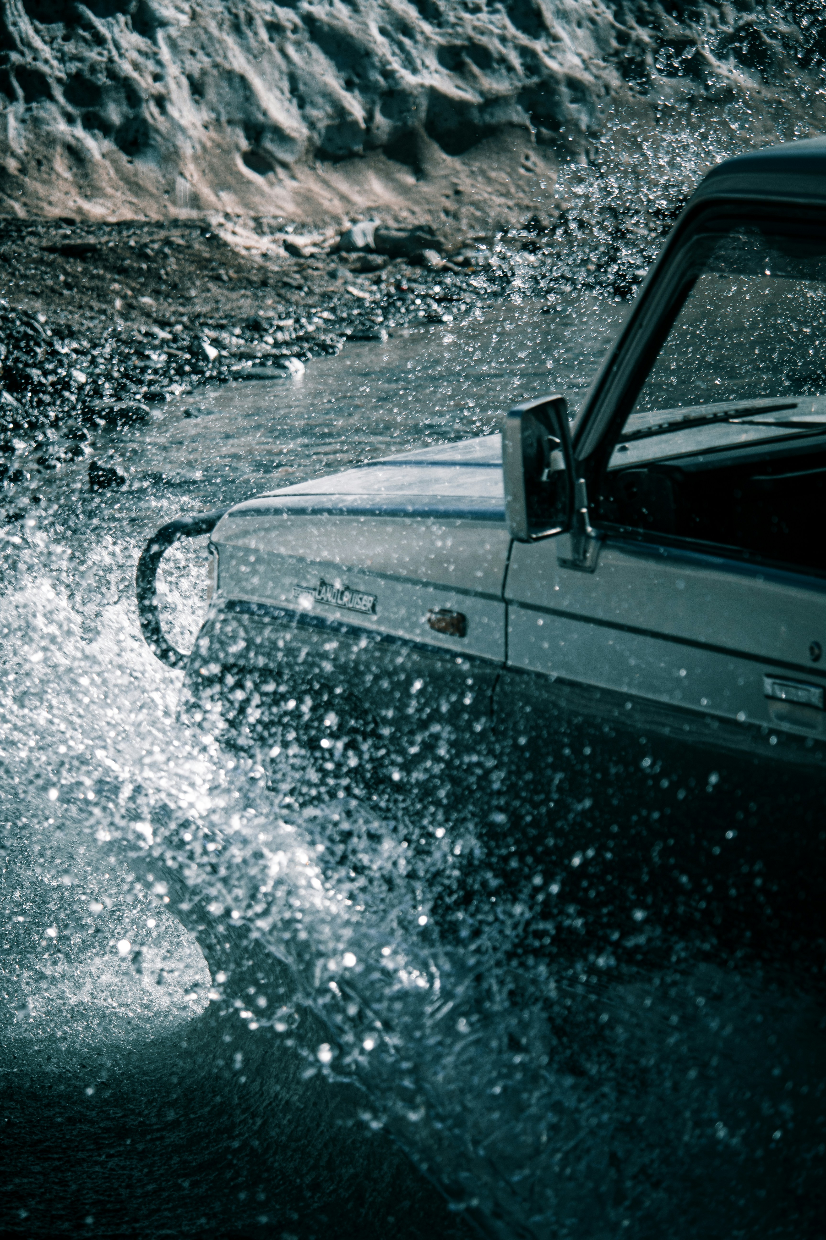 Ironclad in the spray: a vintage SUV carving through seaway mist