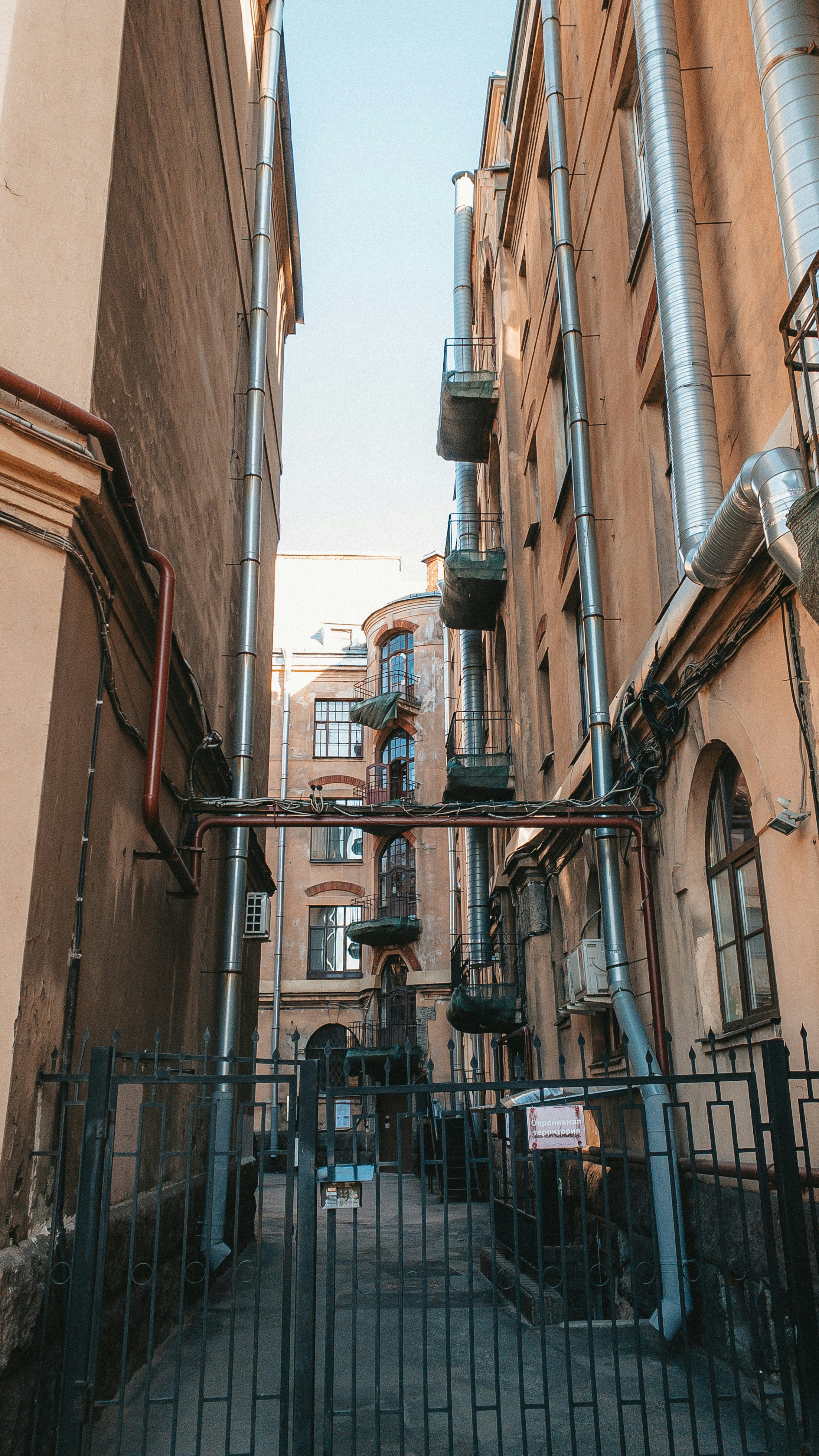 Between Brick Facades: An Alley Framed by Ductwork and Light