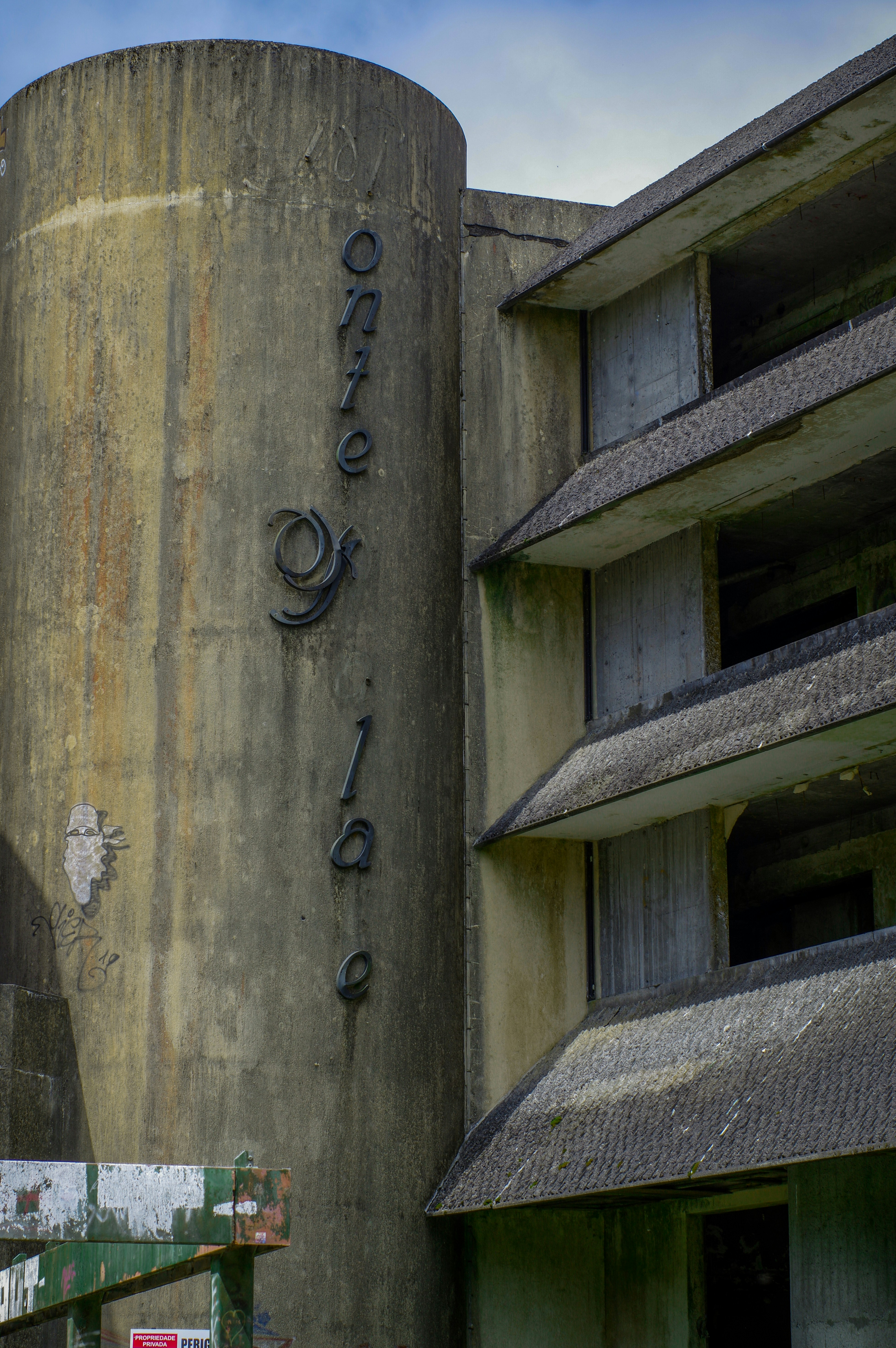 Vertical Signage on a Weathered Brutalist Tower
