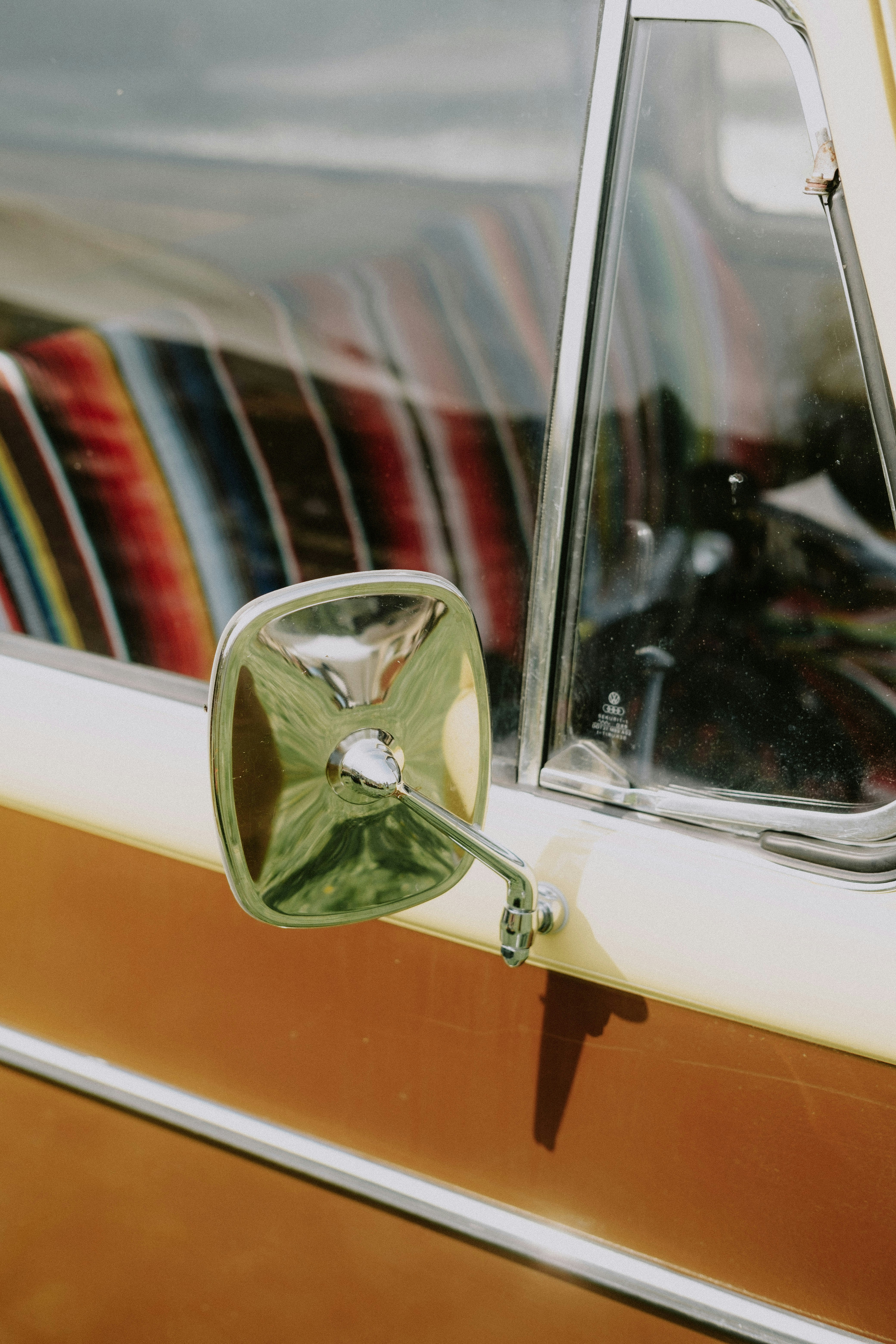 Reflective Chrome and Color: Vintage Side Mirror Close-Up on a Two-Tone Car