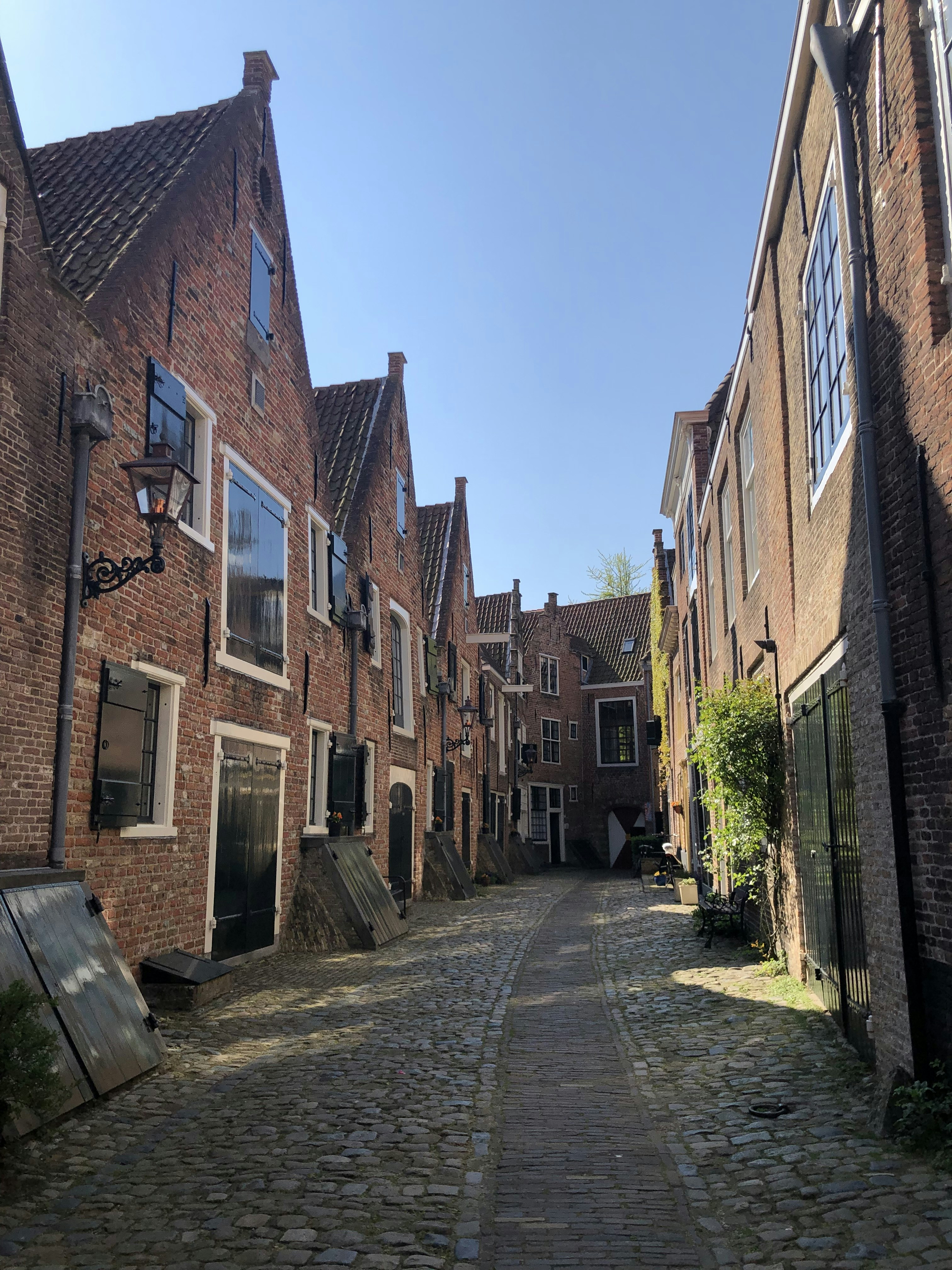 A cobblestone street between brick buildings photo – Free Middelburg ...