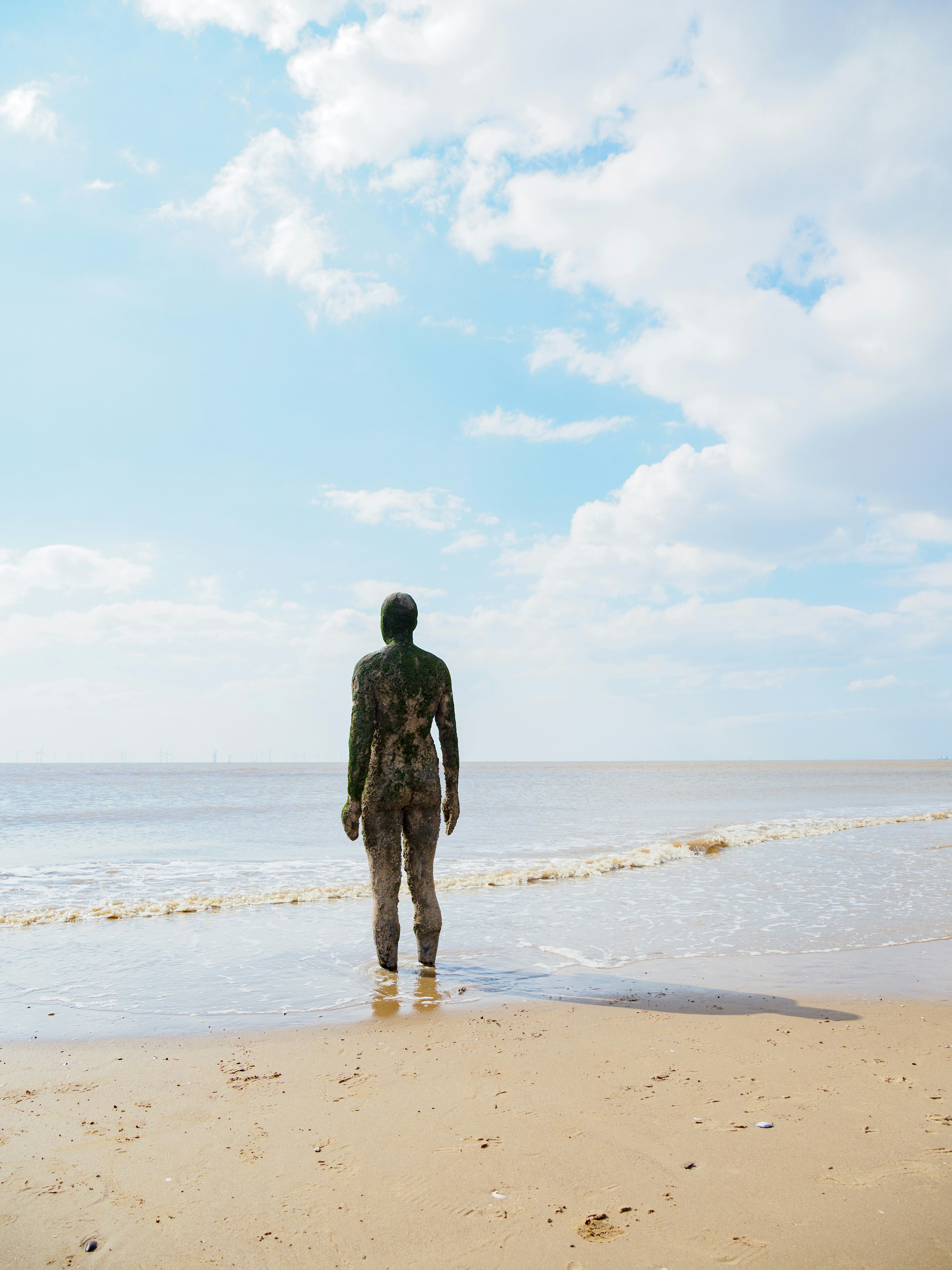 A statue of a man on a beach photo – Free Standing Image on Unsplash