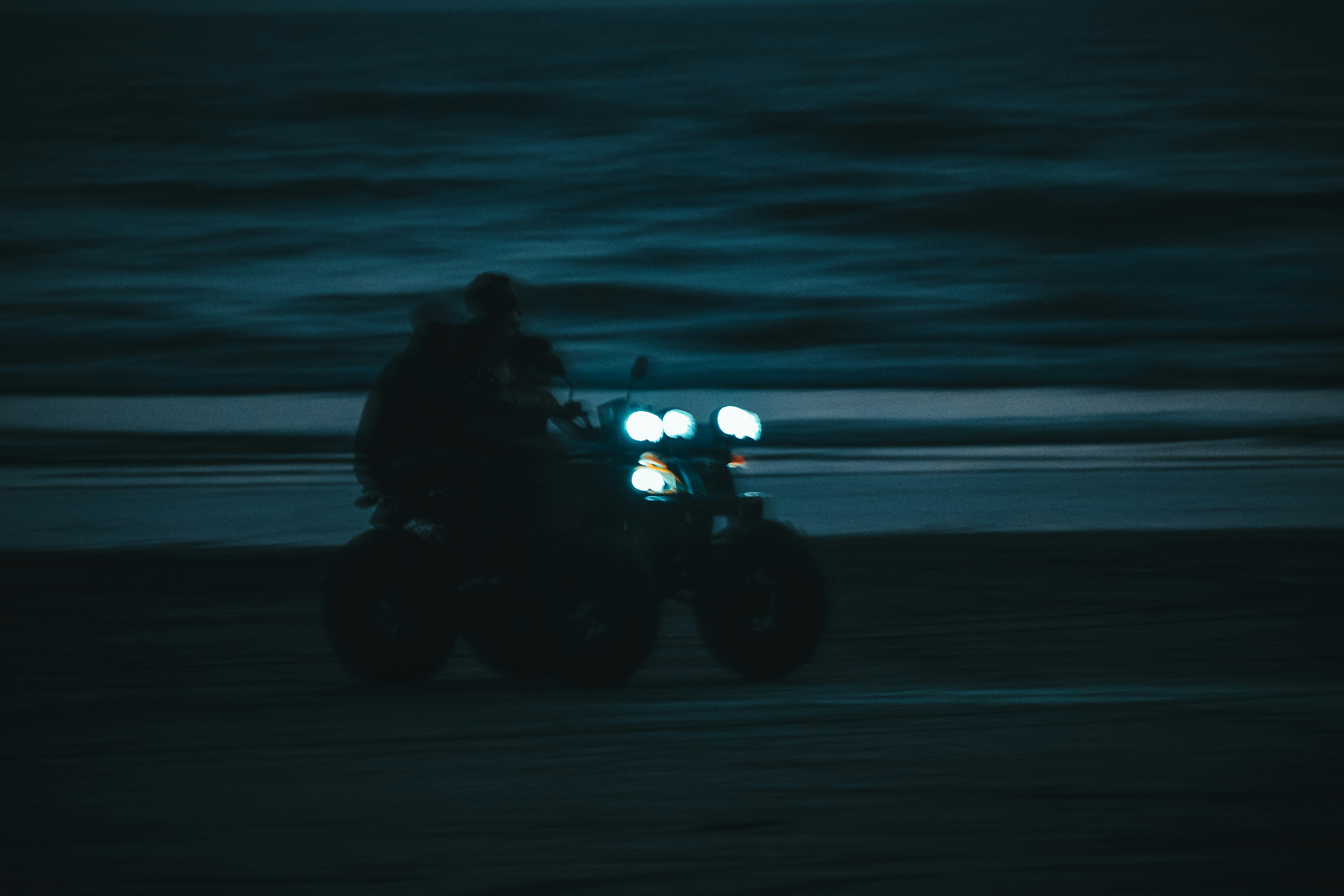 Twin Headlights Drift Along a Moonlit Shore