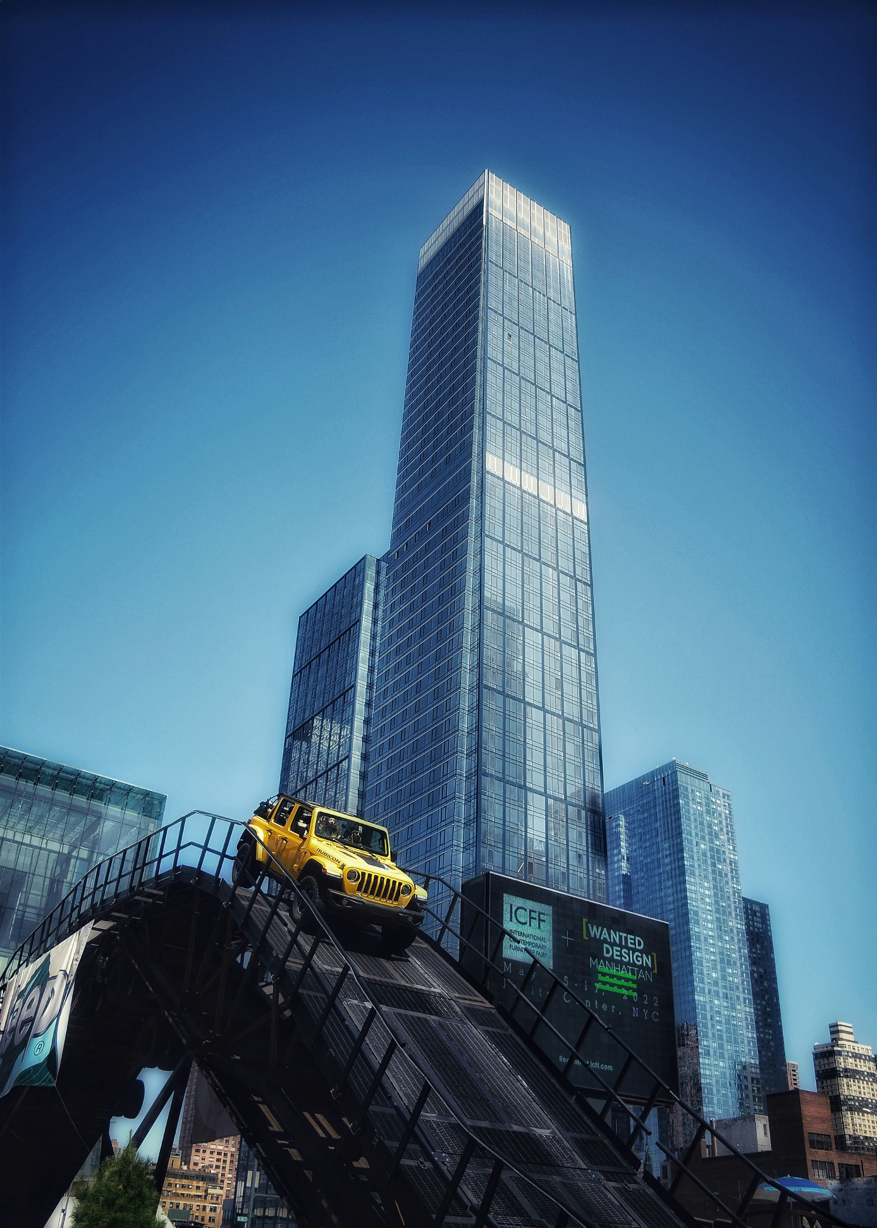 Yellow Jeep on a City Ramp Under a Glass Skyline
