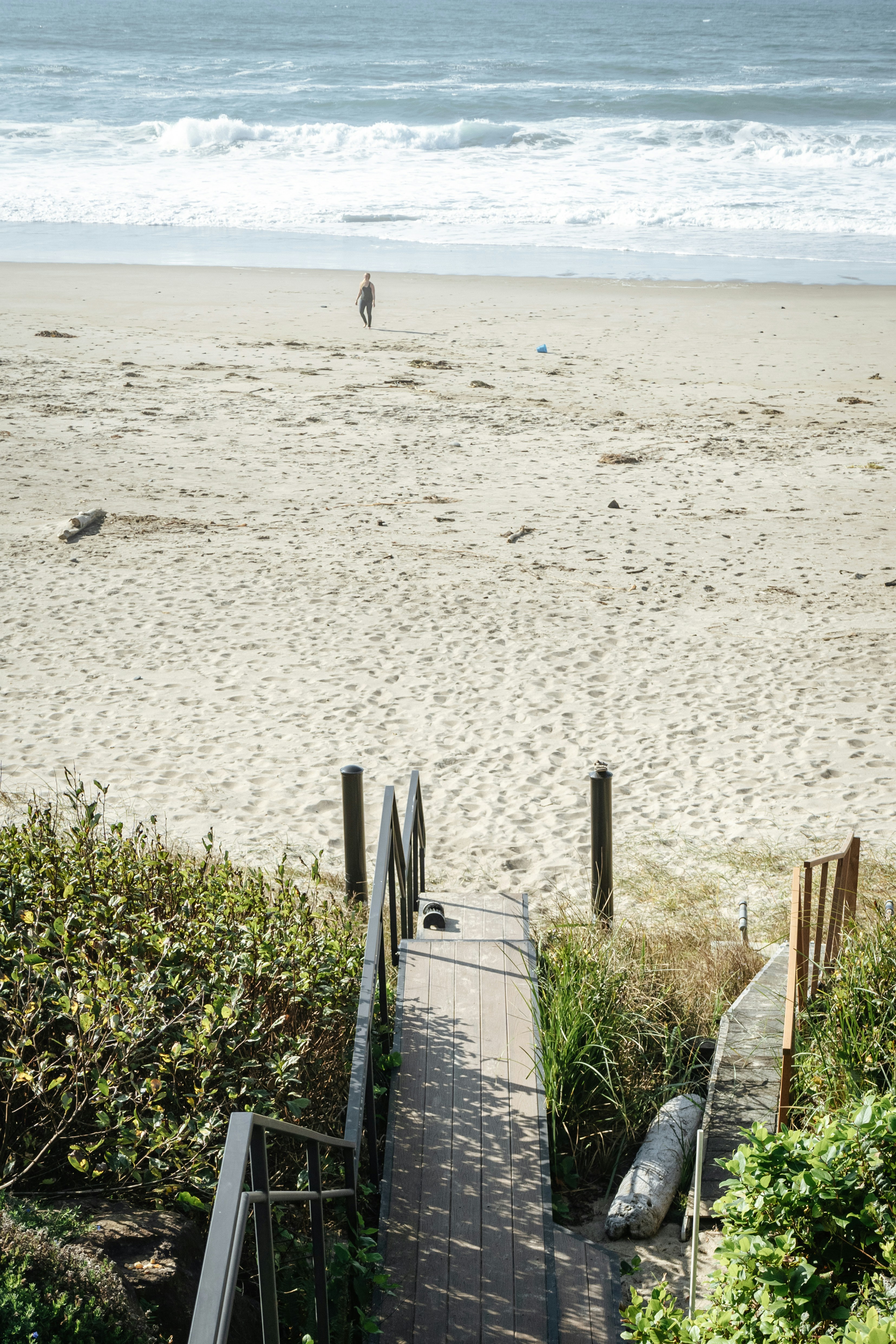 Threshold to the Tide: A Lone Figure on a Narrow Boardwalk