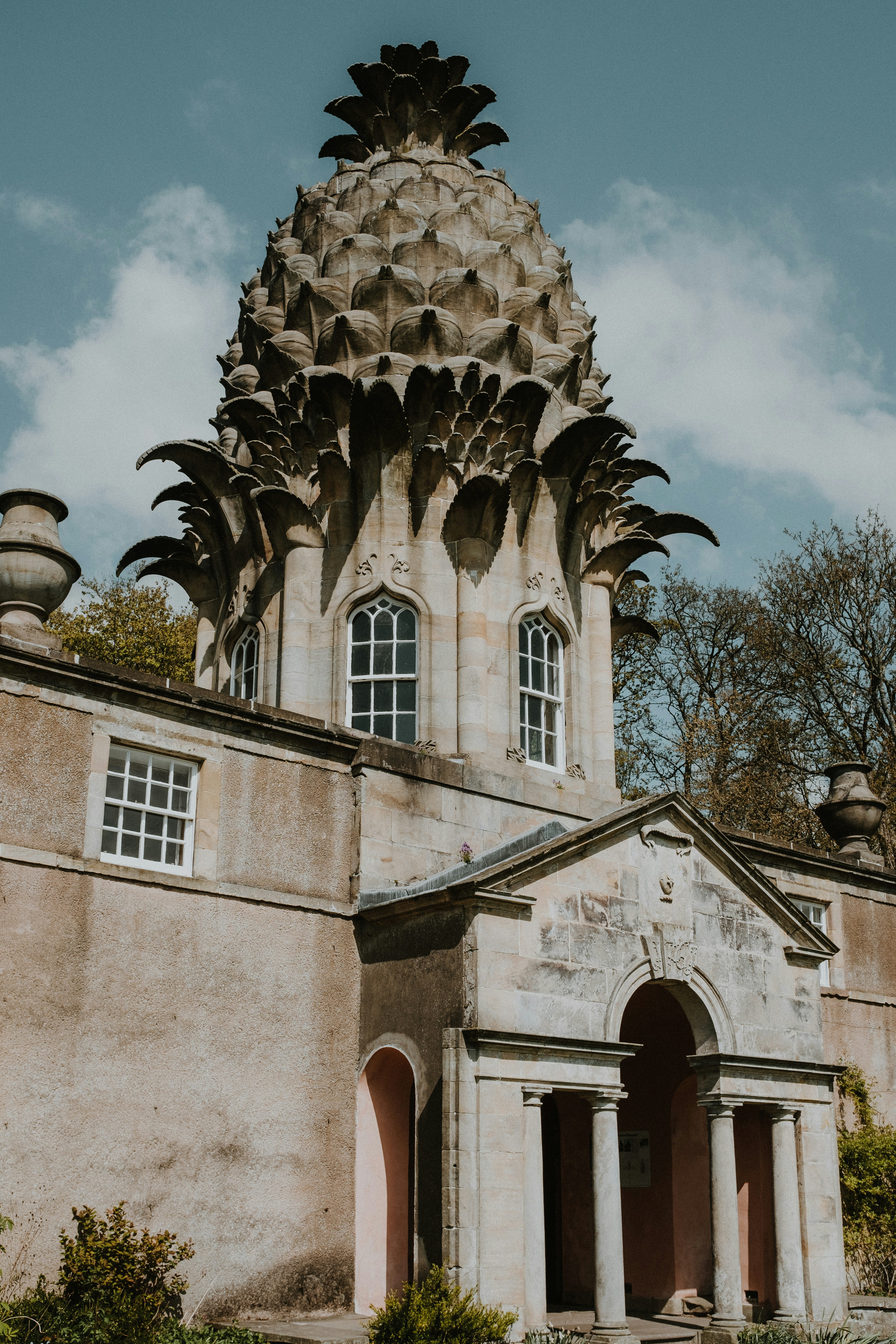 Pinecone Spire Rising Over a Weathered Stone Manor