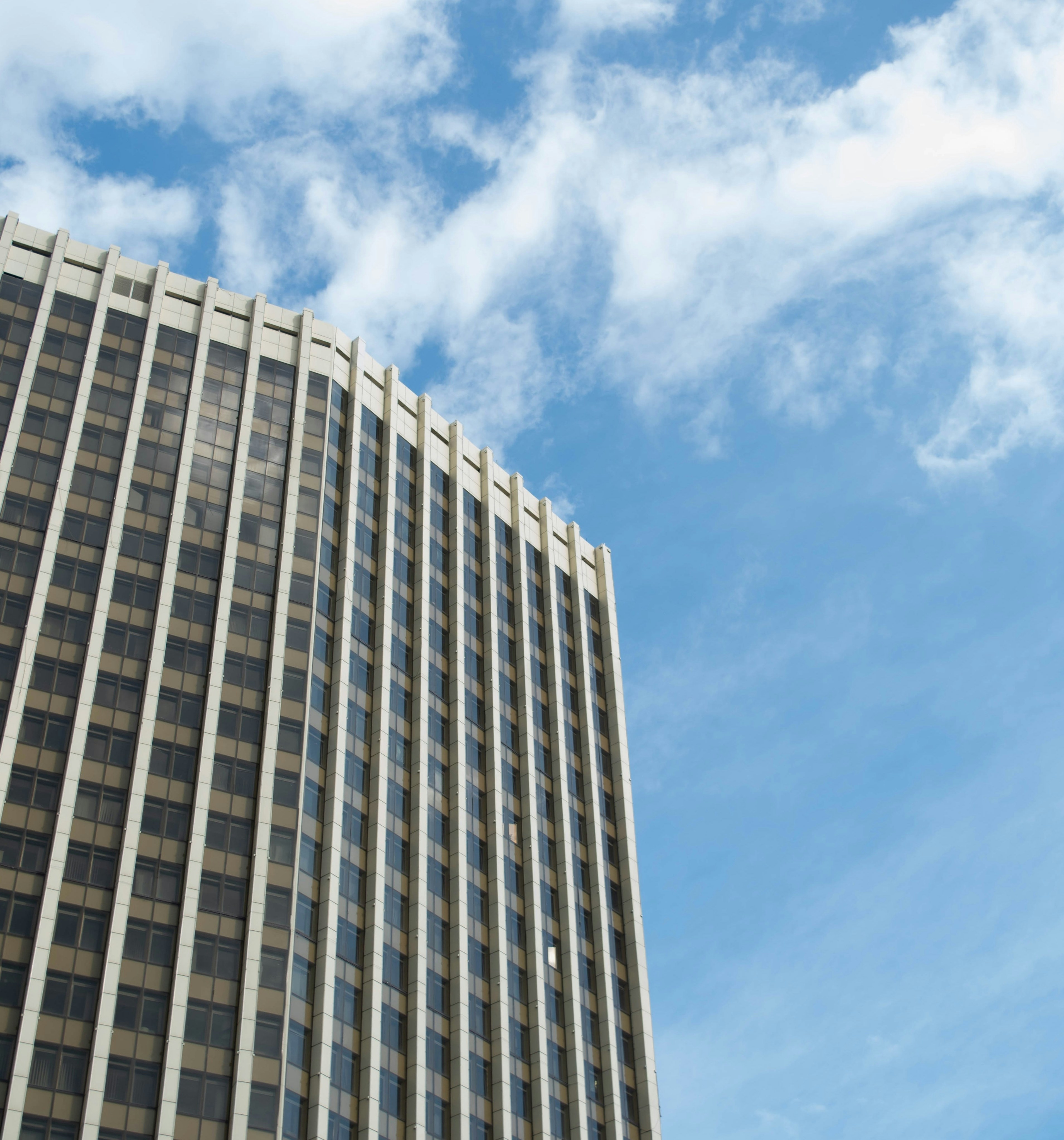 A tall building with clouds in the sky photo – Free Grey Image on Unsplash