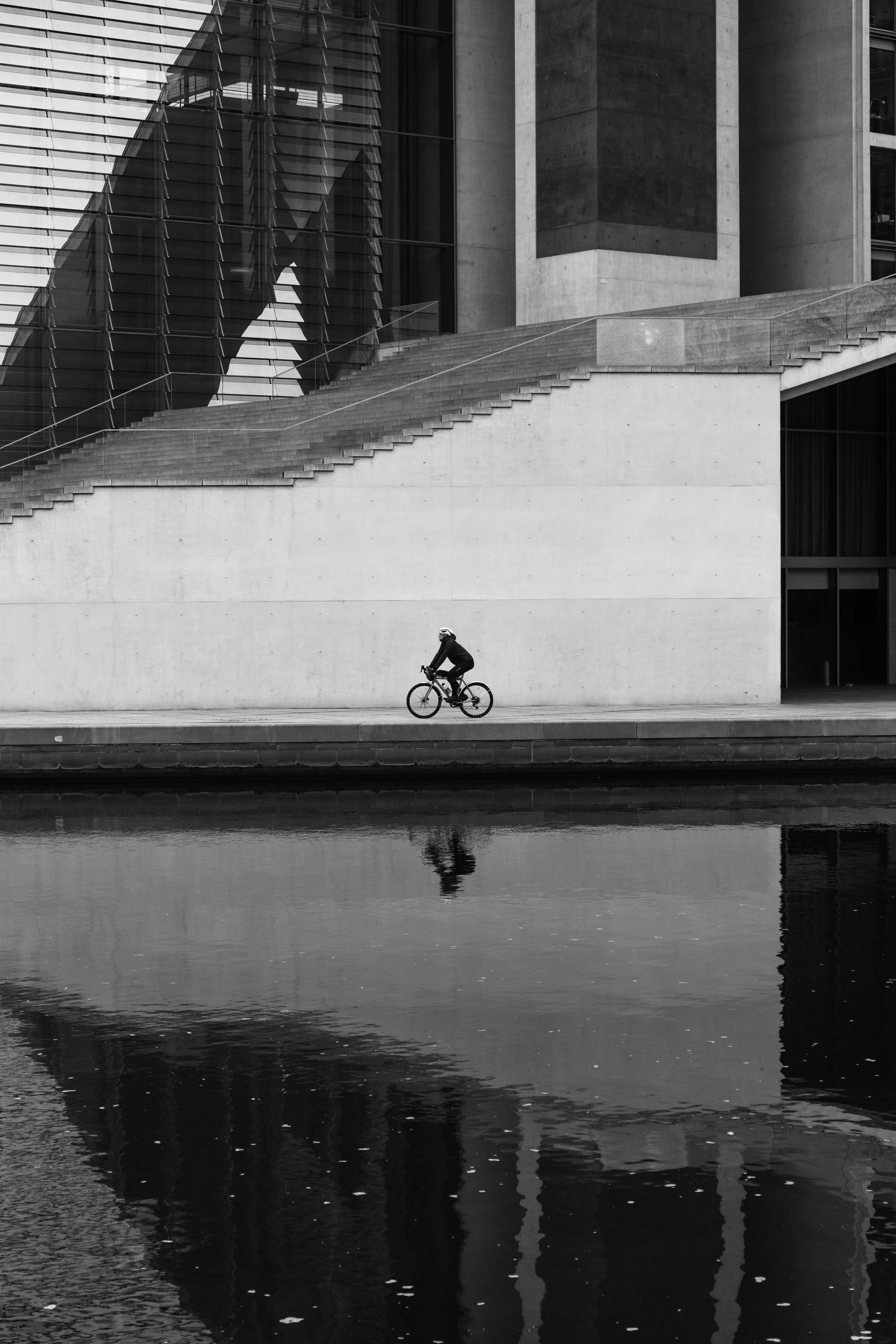Rider on the Canal: Quiet Geometry of Concrete, Glass, and Reflection