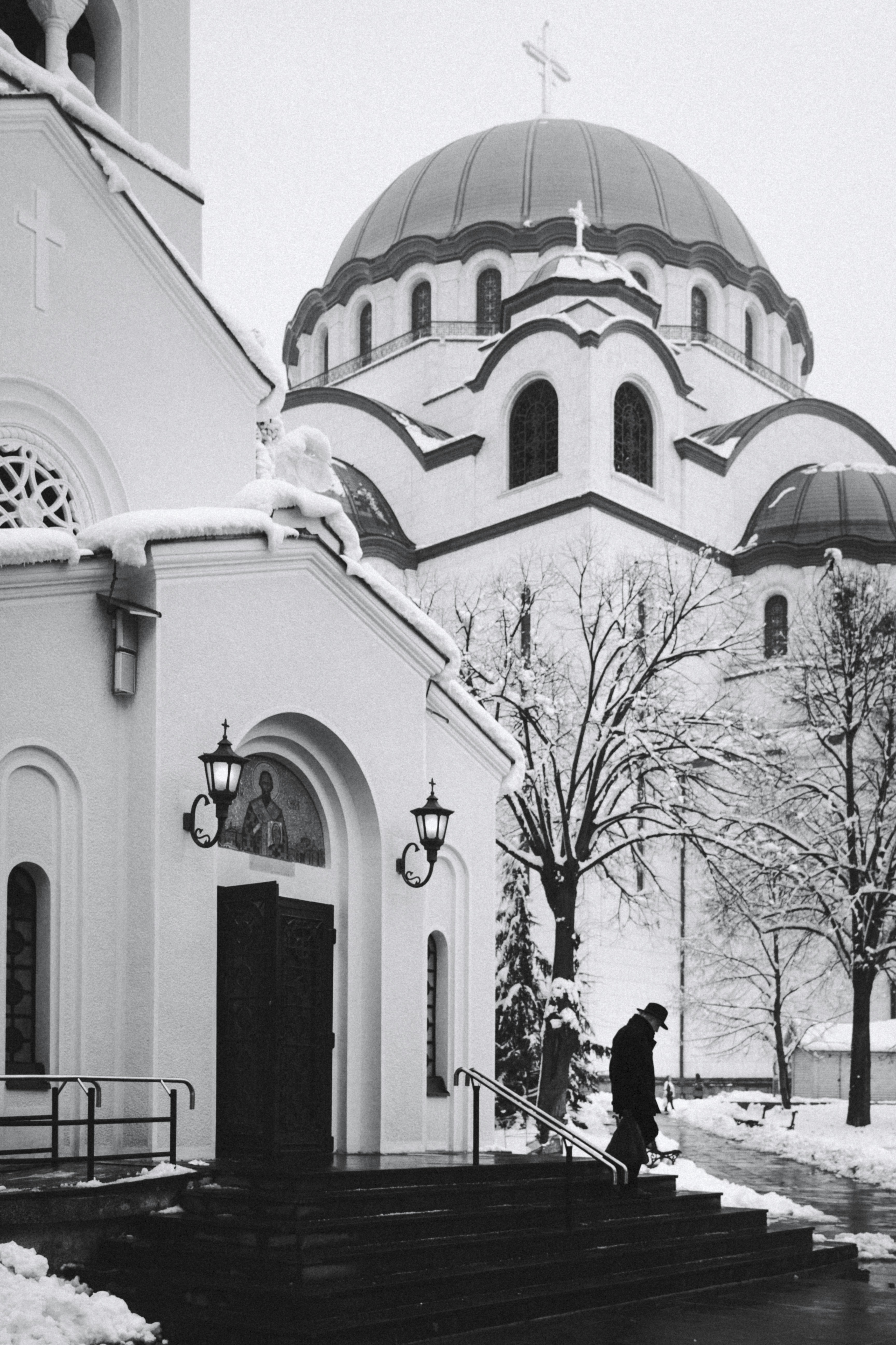 Snow-covered steps leading to the Saint Sava Cathedral set against a wintry backdrop.