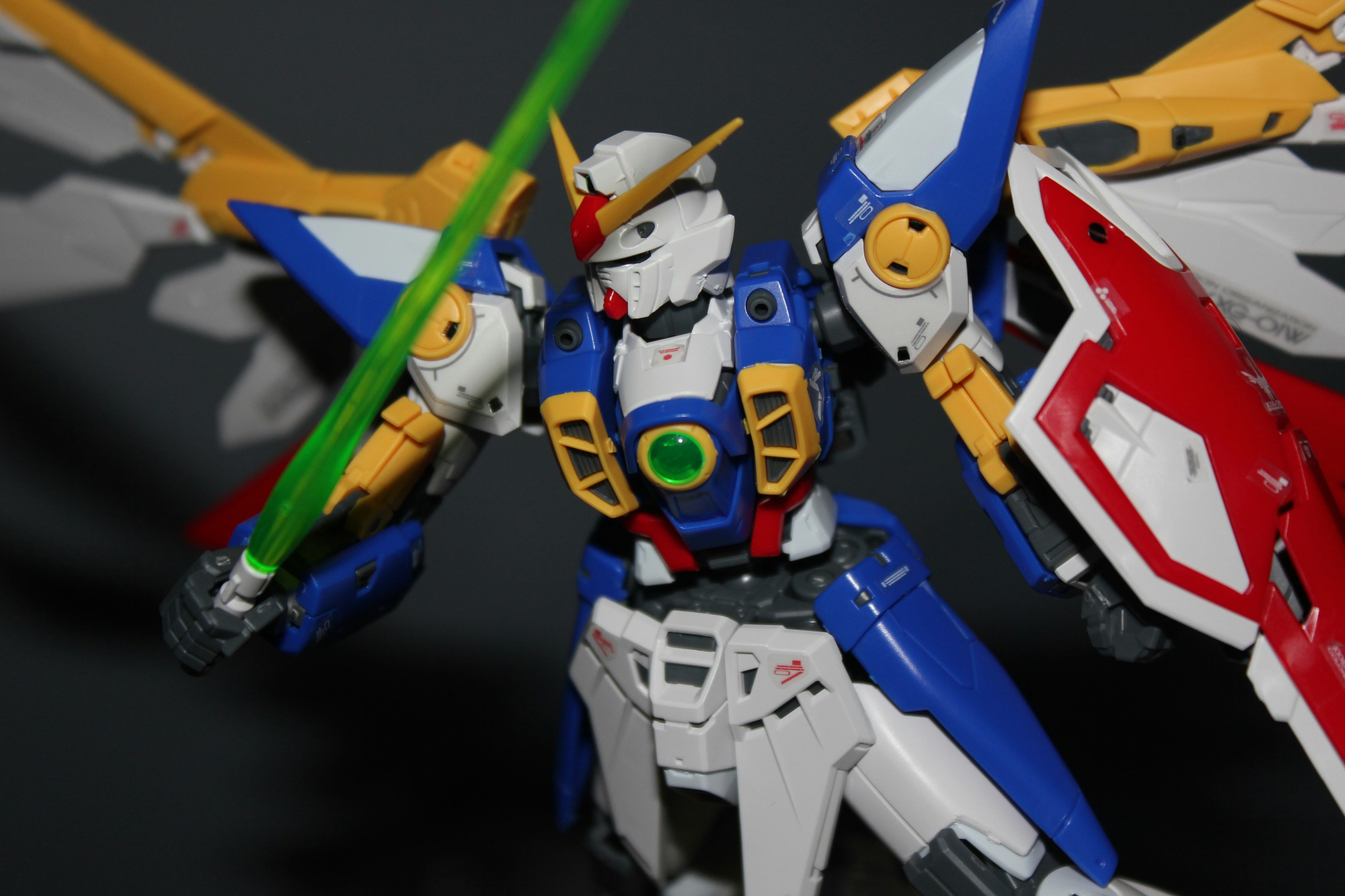 A detailed model of a mecha wielding a green energy sword, poised for action against a dark backdrop.