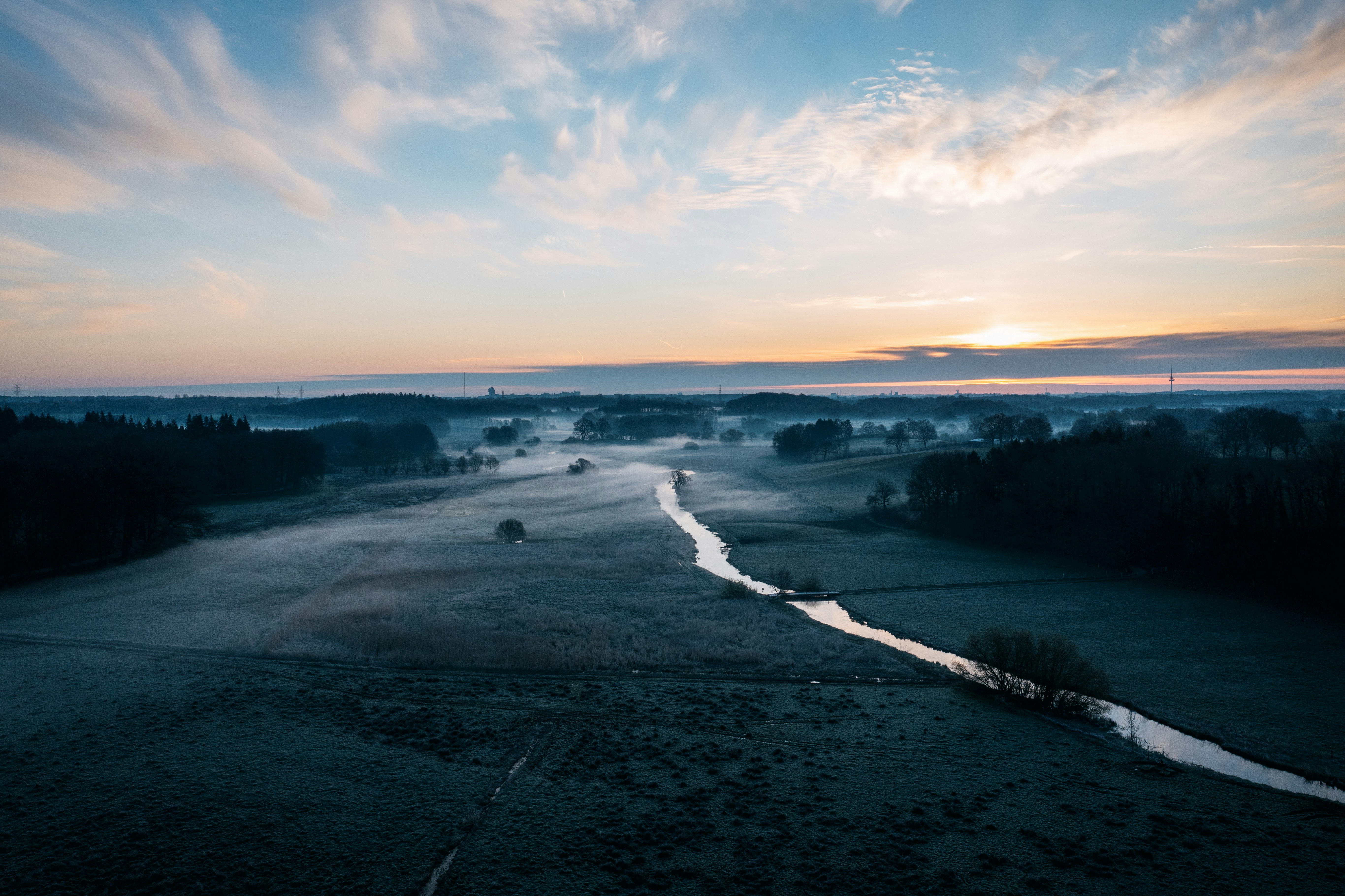 Dawn's Silver Ribbon: A River Winding Through Misty Farmlands