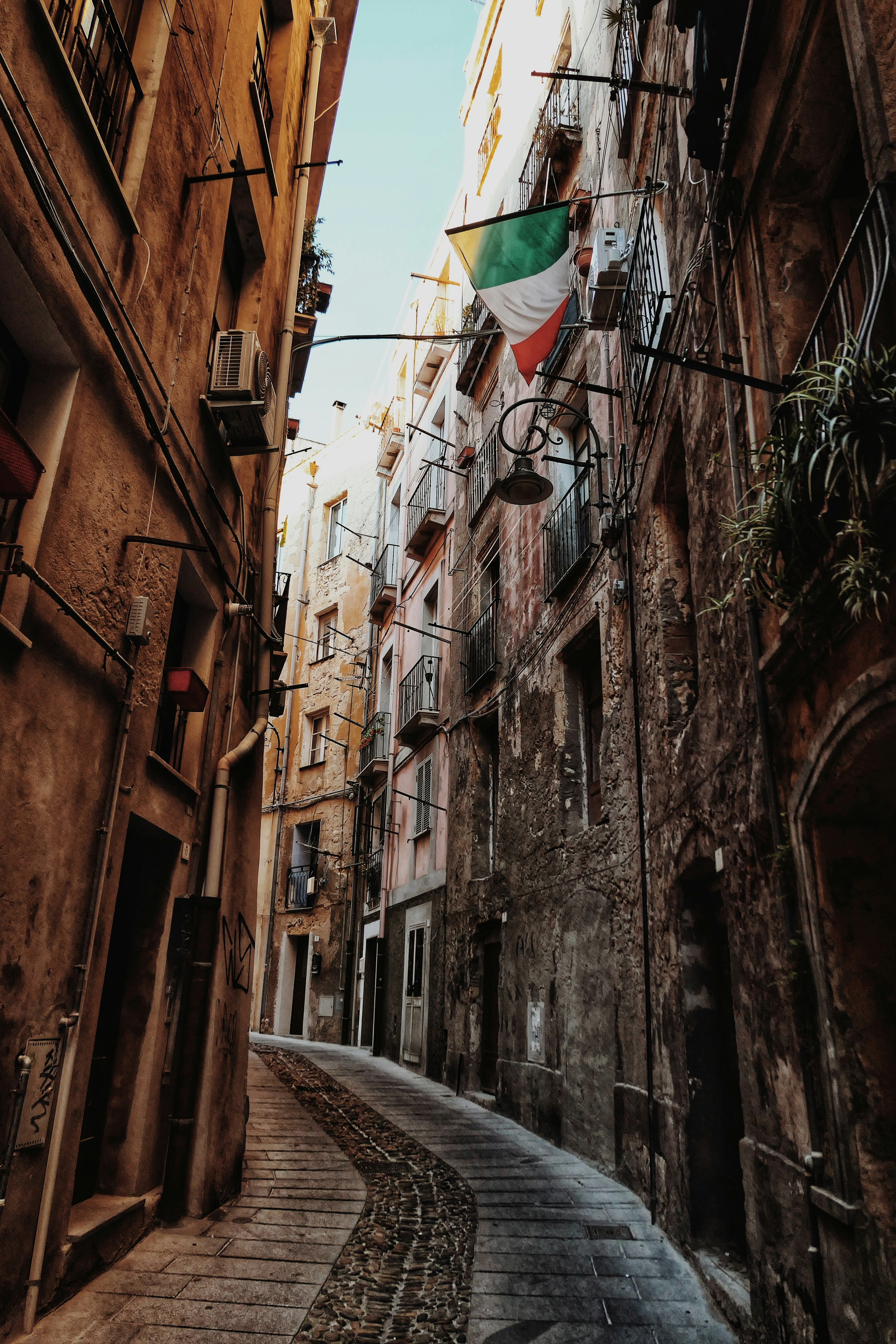 A narrow street with buildings on both sides photo – Free Road Image on ...