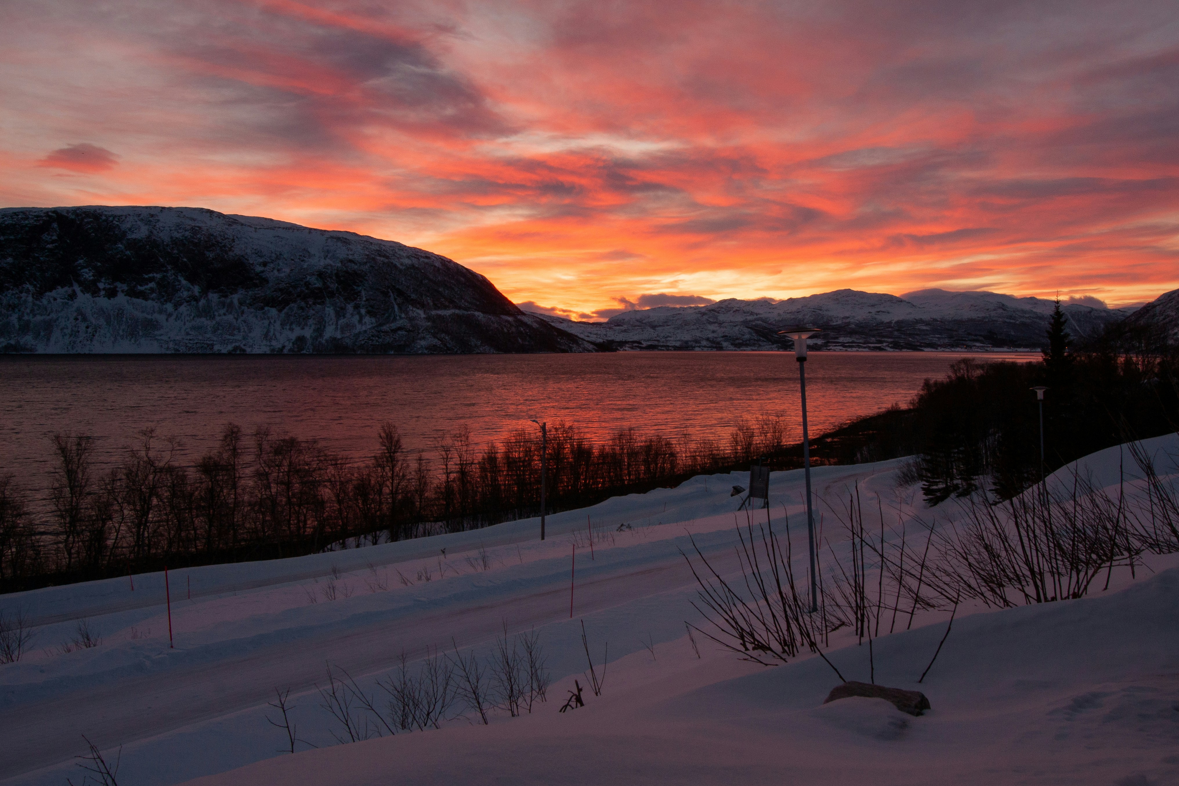Crimson Crest over Snowbound Fjord at Dusk
