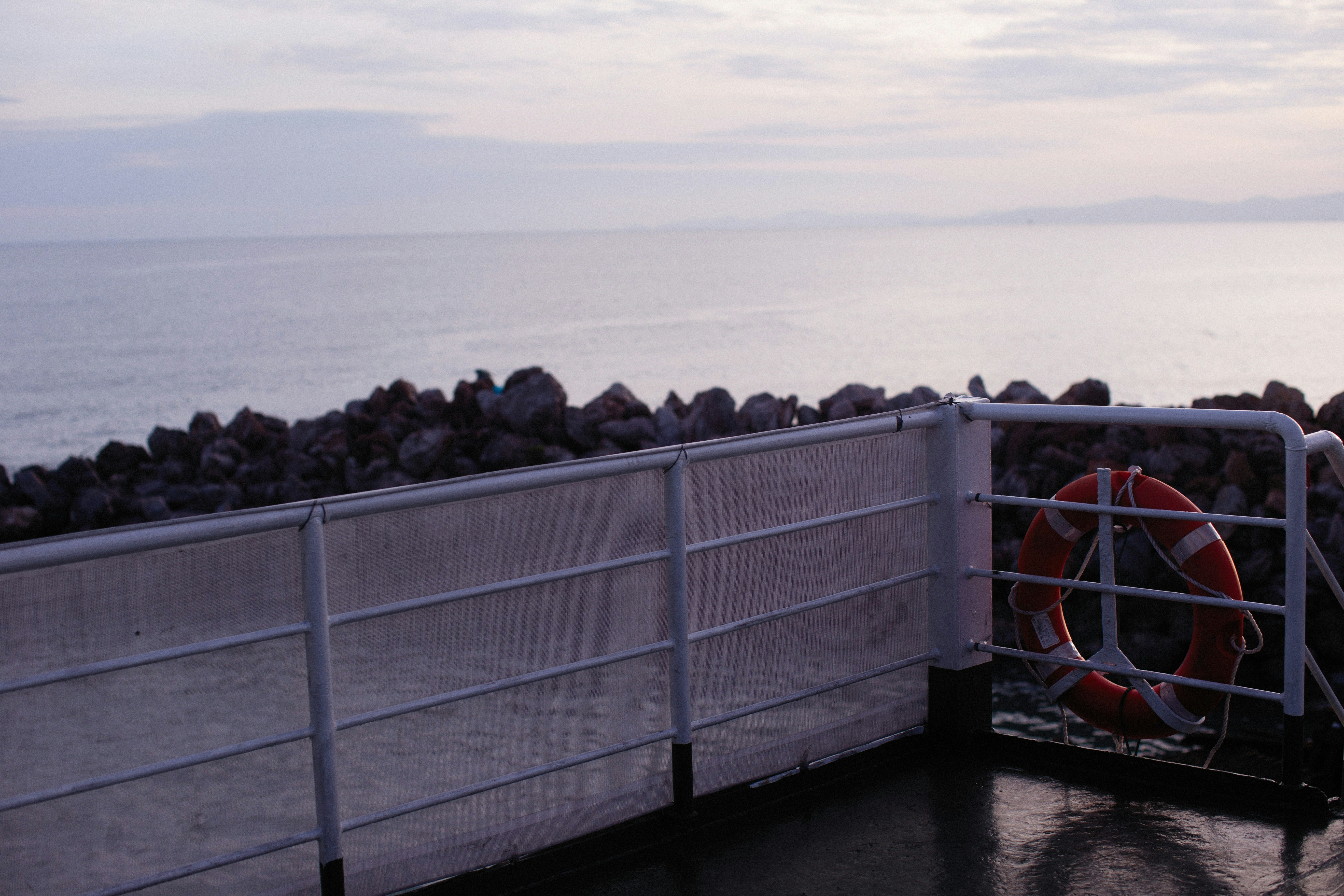 A railing overlooking a body of water photo – Free Port Image on Unsplash