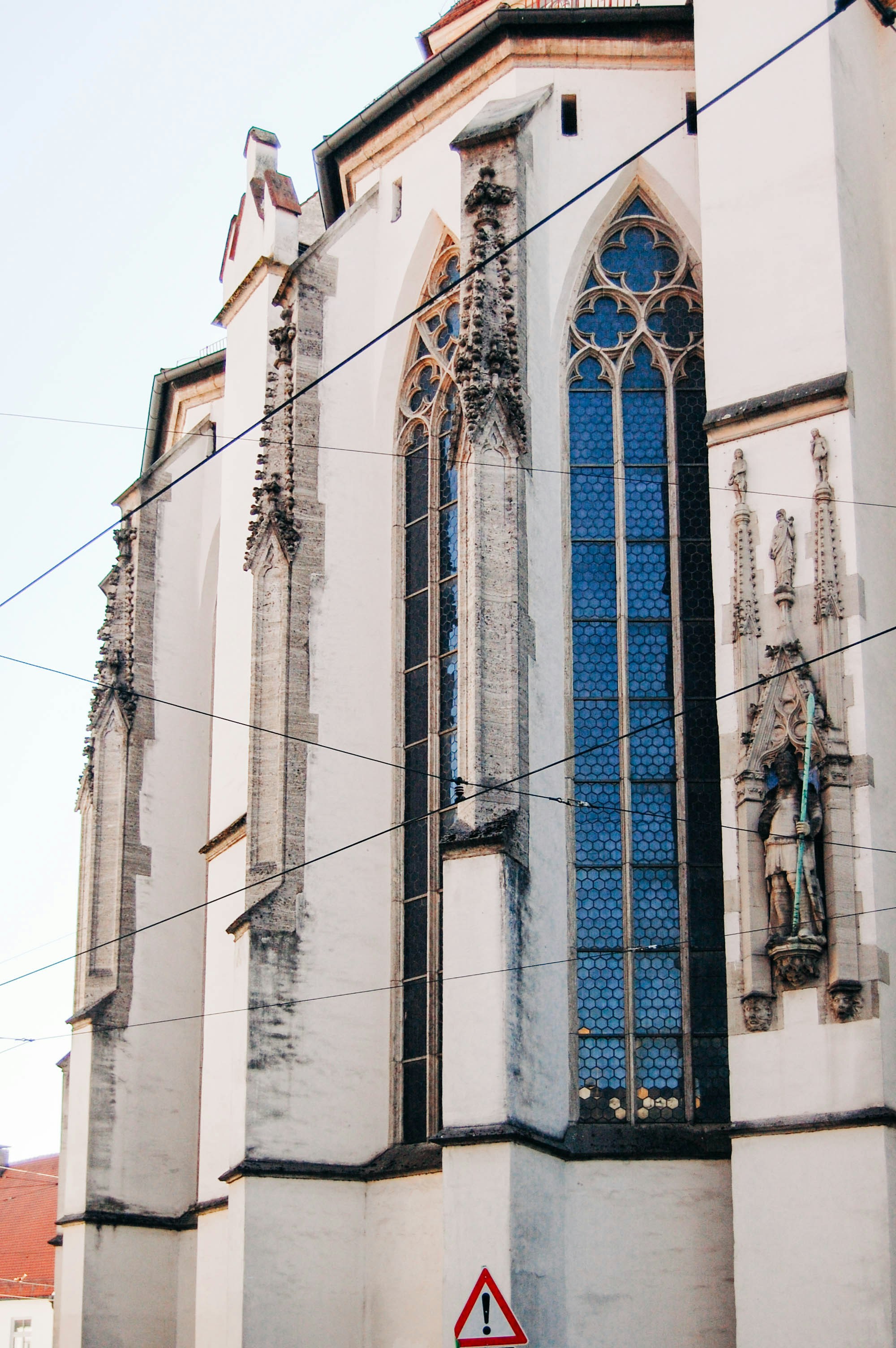 Crisscrossed Cables Framing a Gothic Church Facade with Stained-Glass Arches