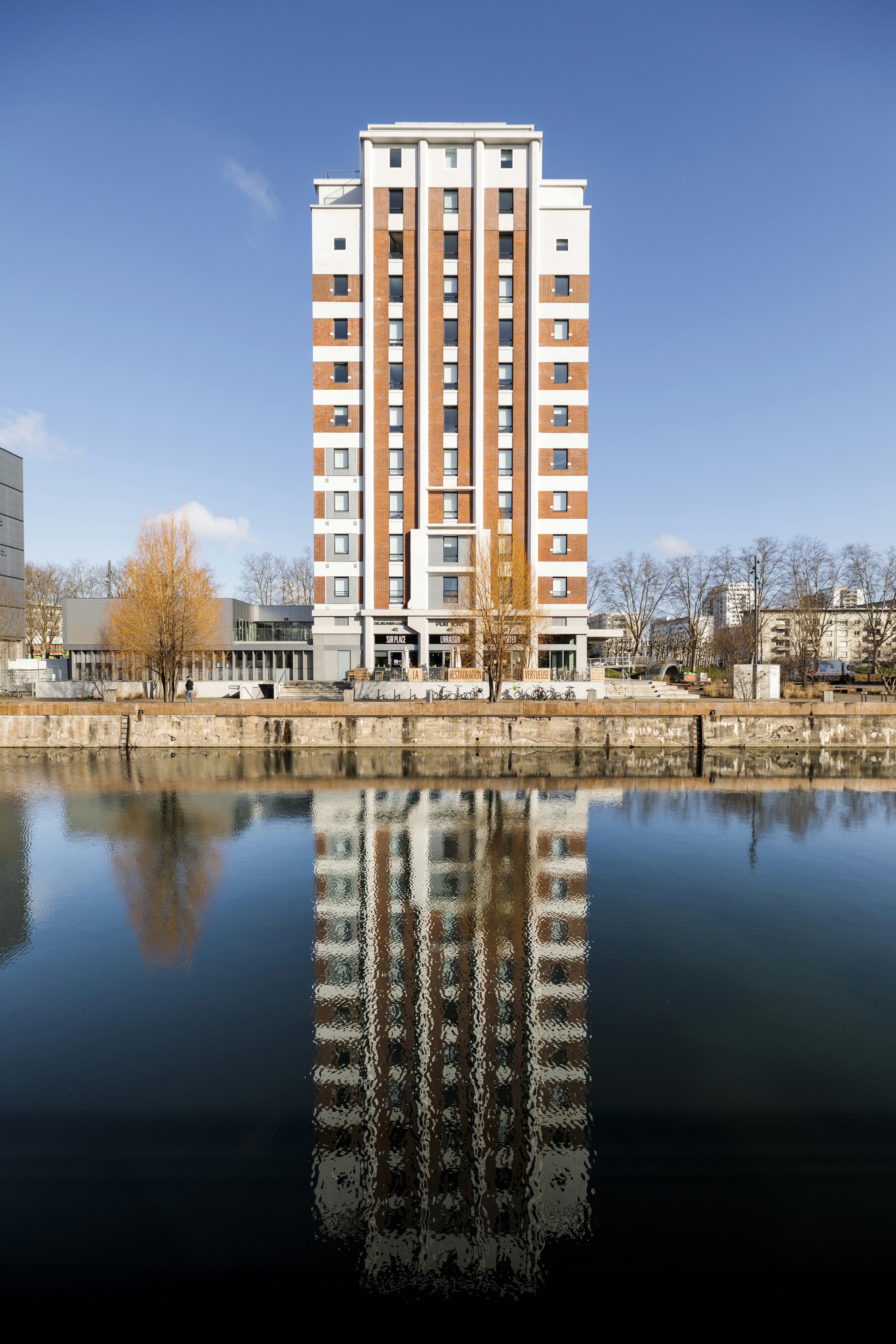 Symmetrical riverside tower: mirrored in still waters