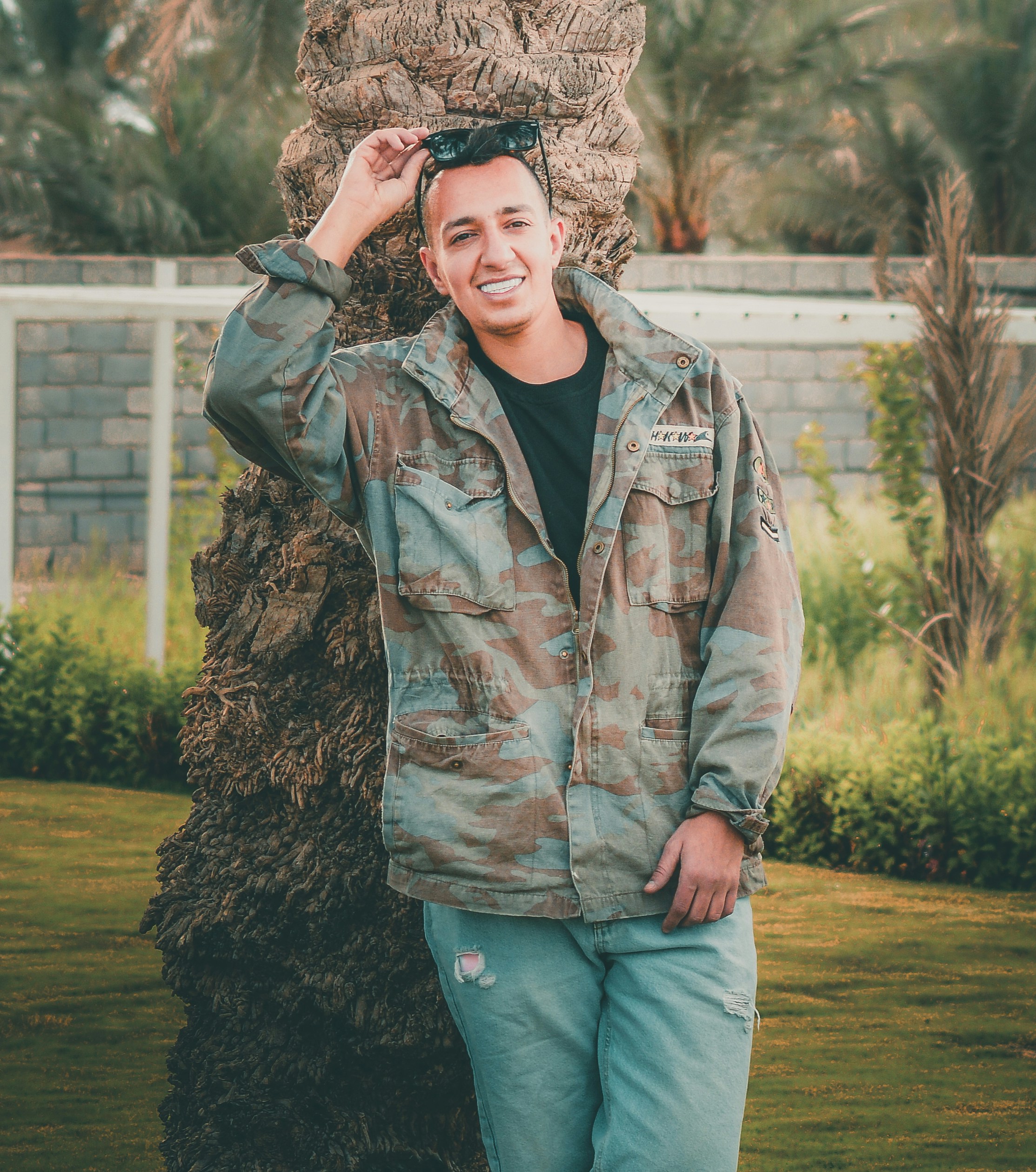 Casual confidant by the palm: a relaxed portrait in soft light