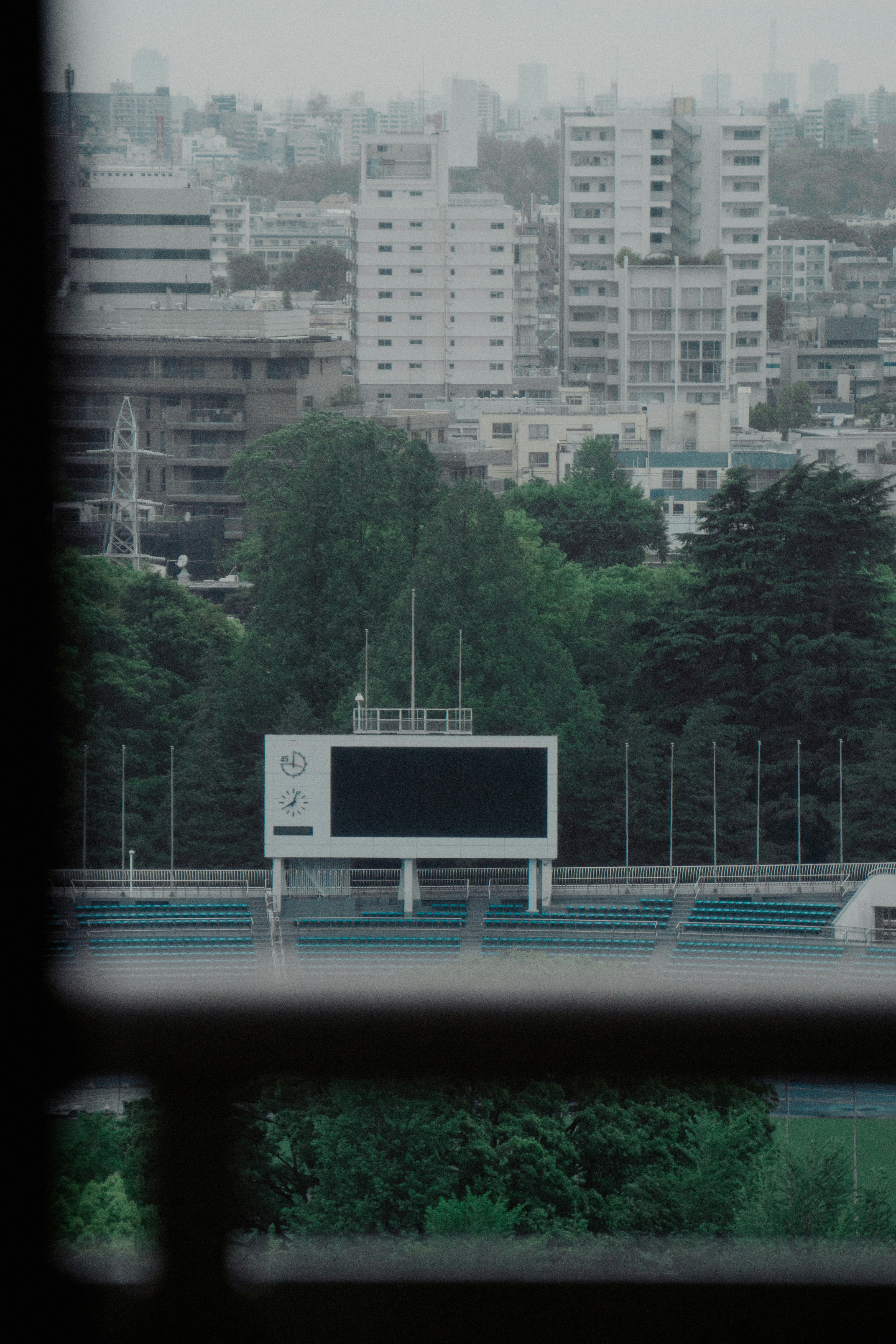 Empty Scoreboard Over Green City: A Quiet Stadium Vista