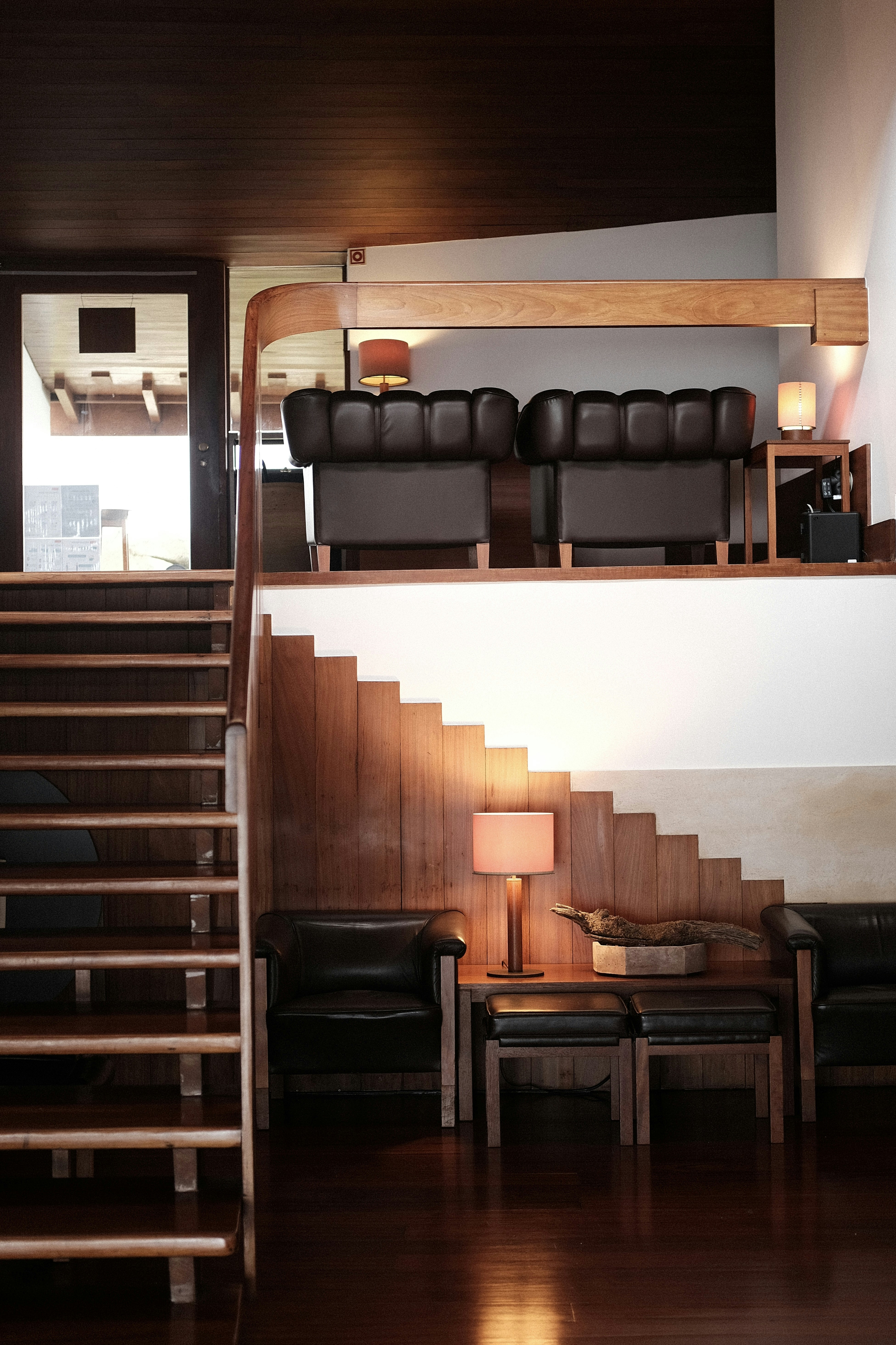 Staircase Echoes: A Mezzanine Lounge Wrapped in Warm Light