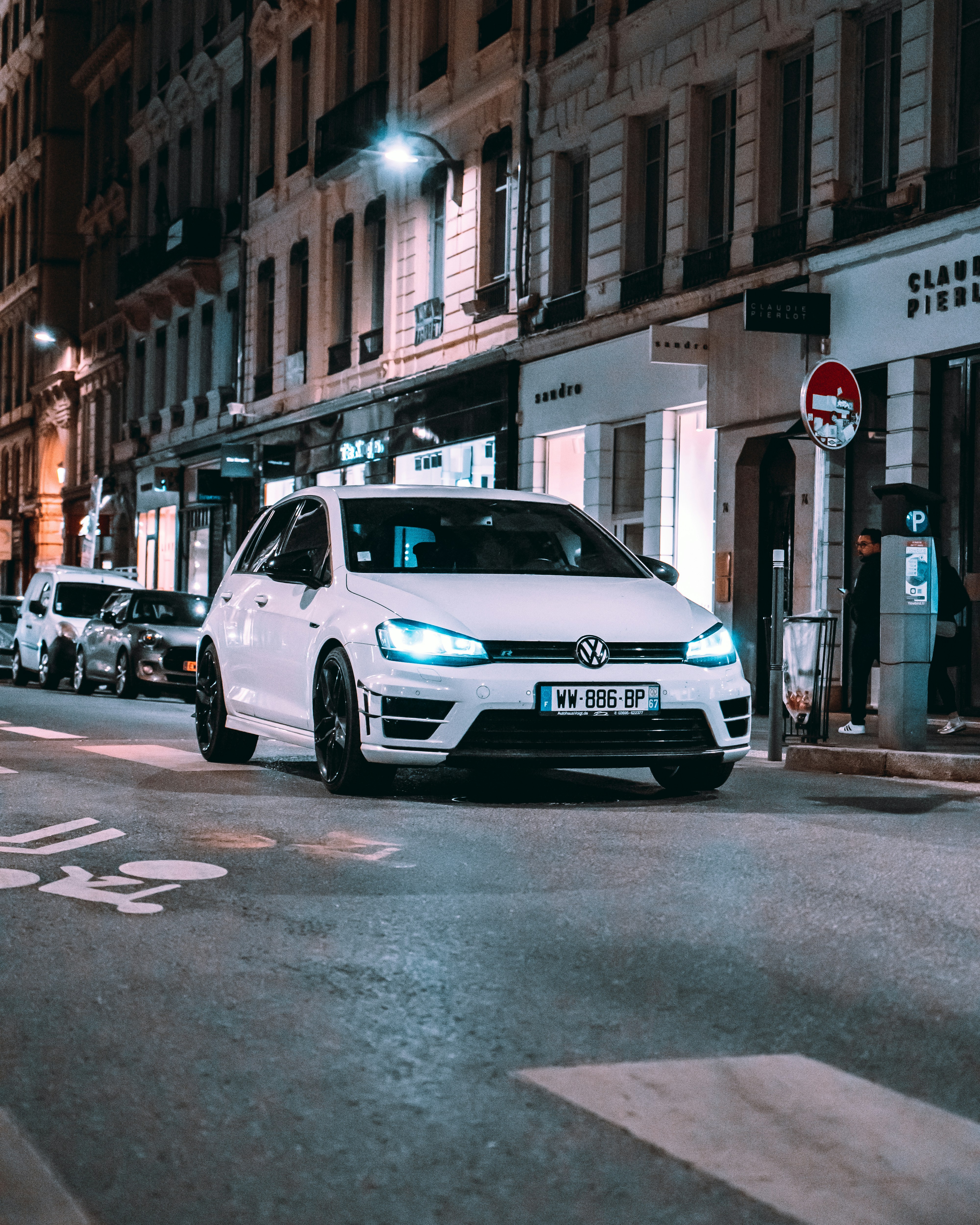 Blue-Headlight Pulse: White VW Roams a Parisian Night Street