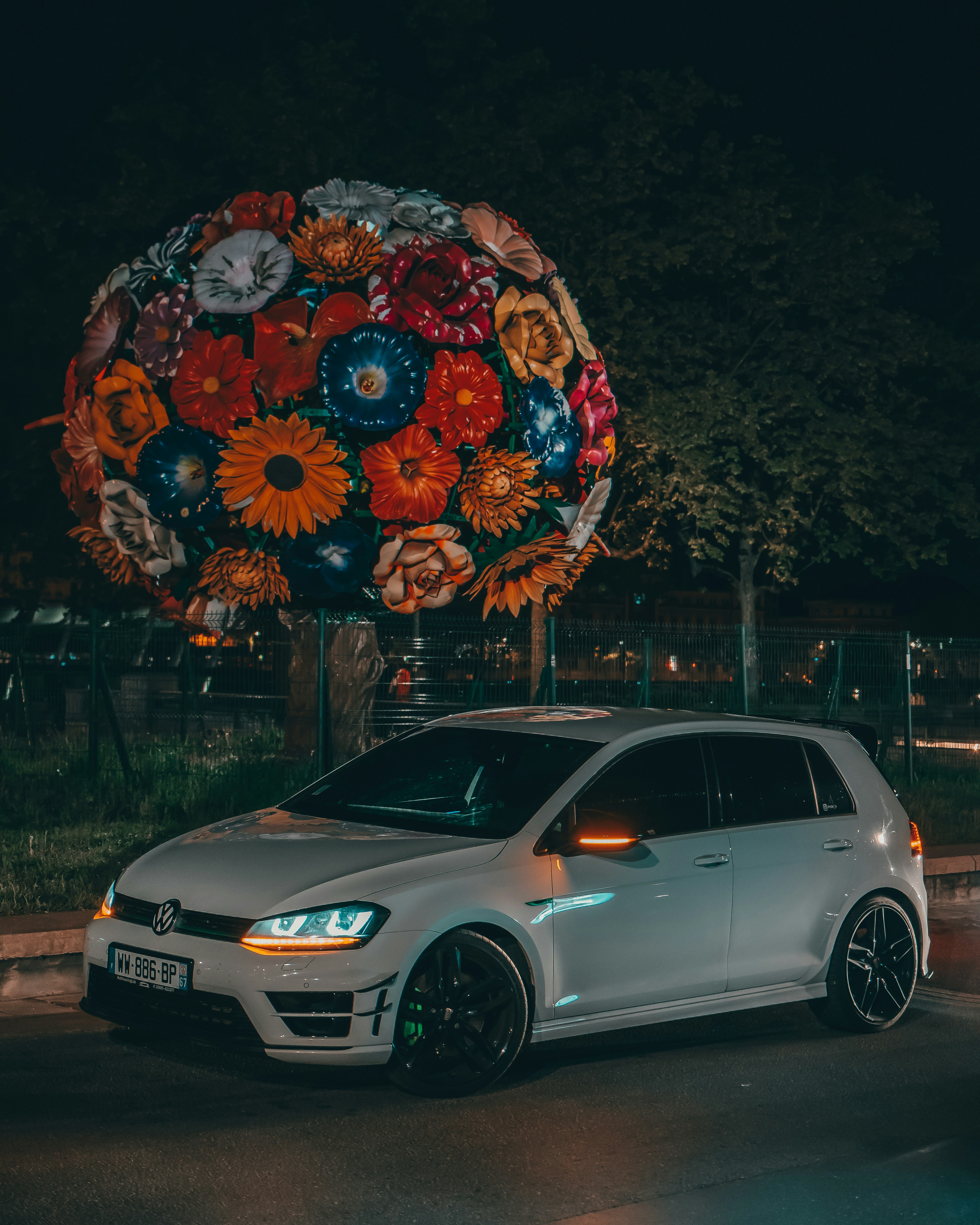 Night Parade: A White VW Trimmed by a Ball of Flowers