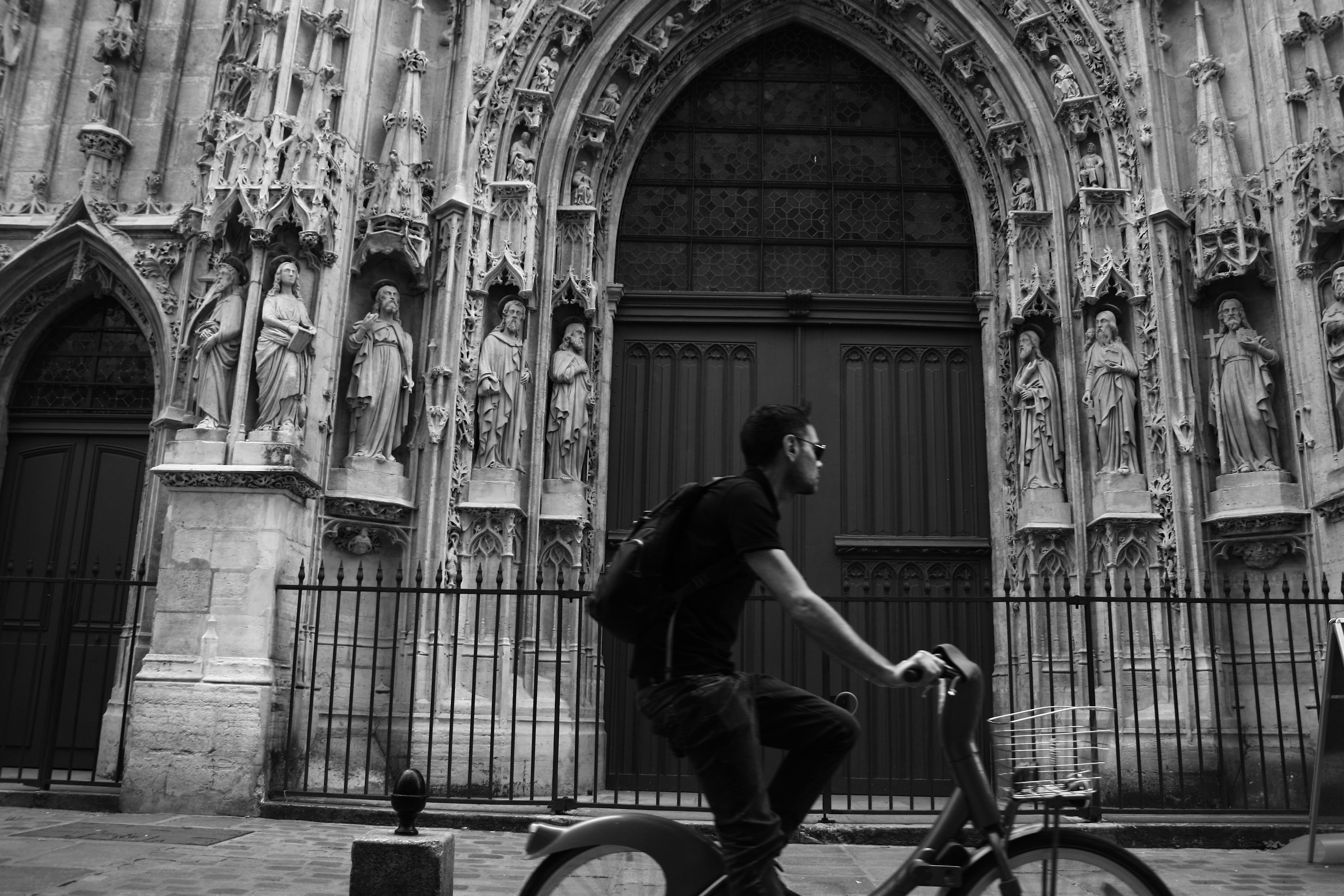 Rider in Contrast: A Cyclist Passes the Gothic Facade