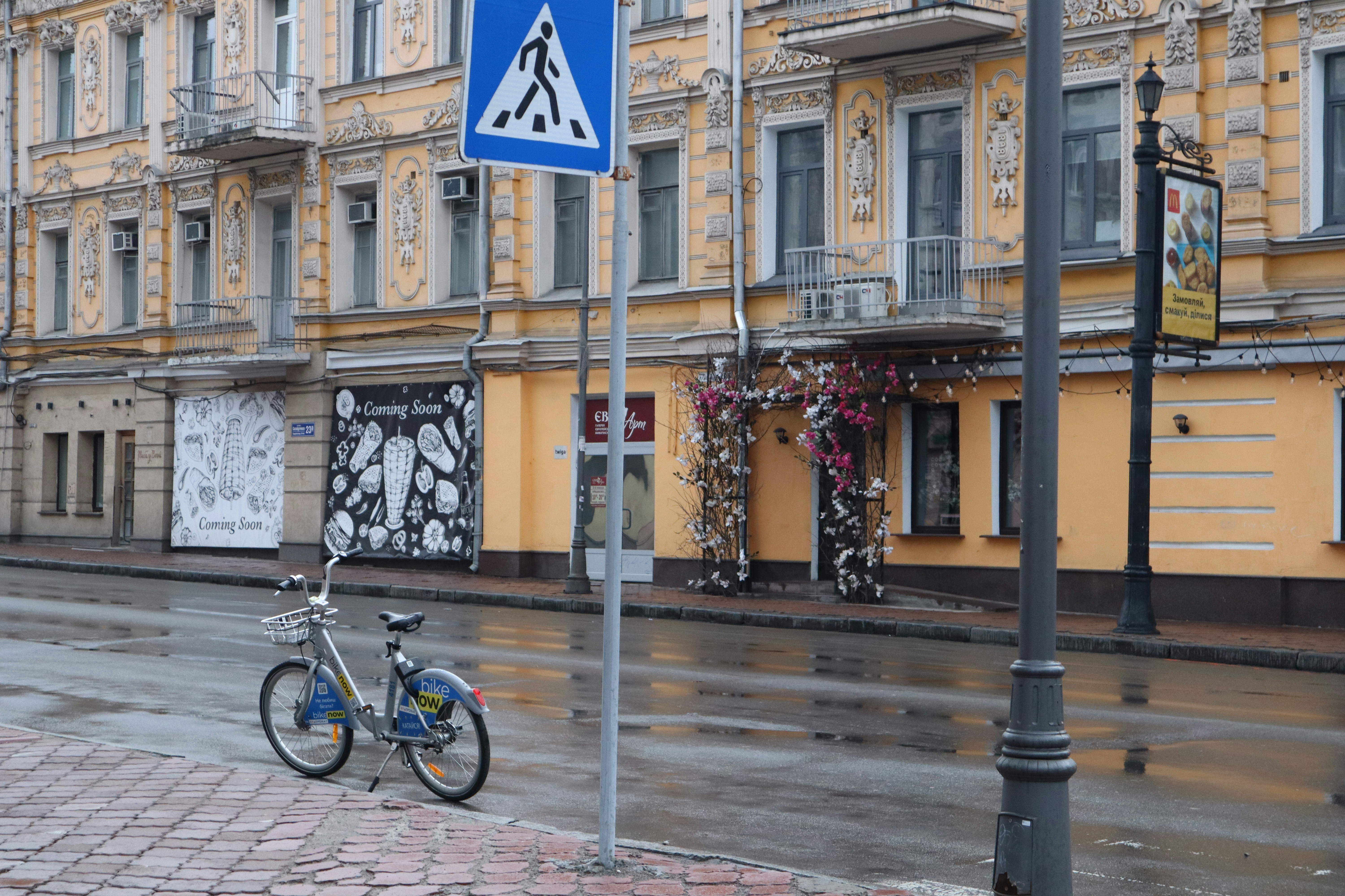 Blue Sign, Yellow Facades: A Quiet Rain-Washed Street Snapshot
