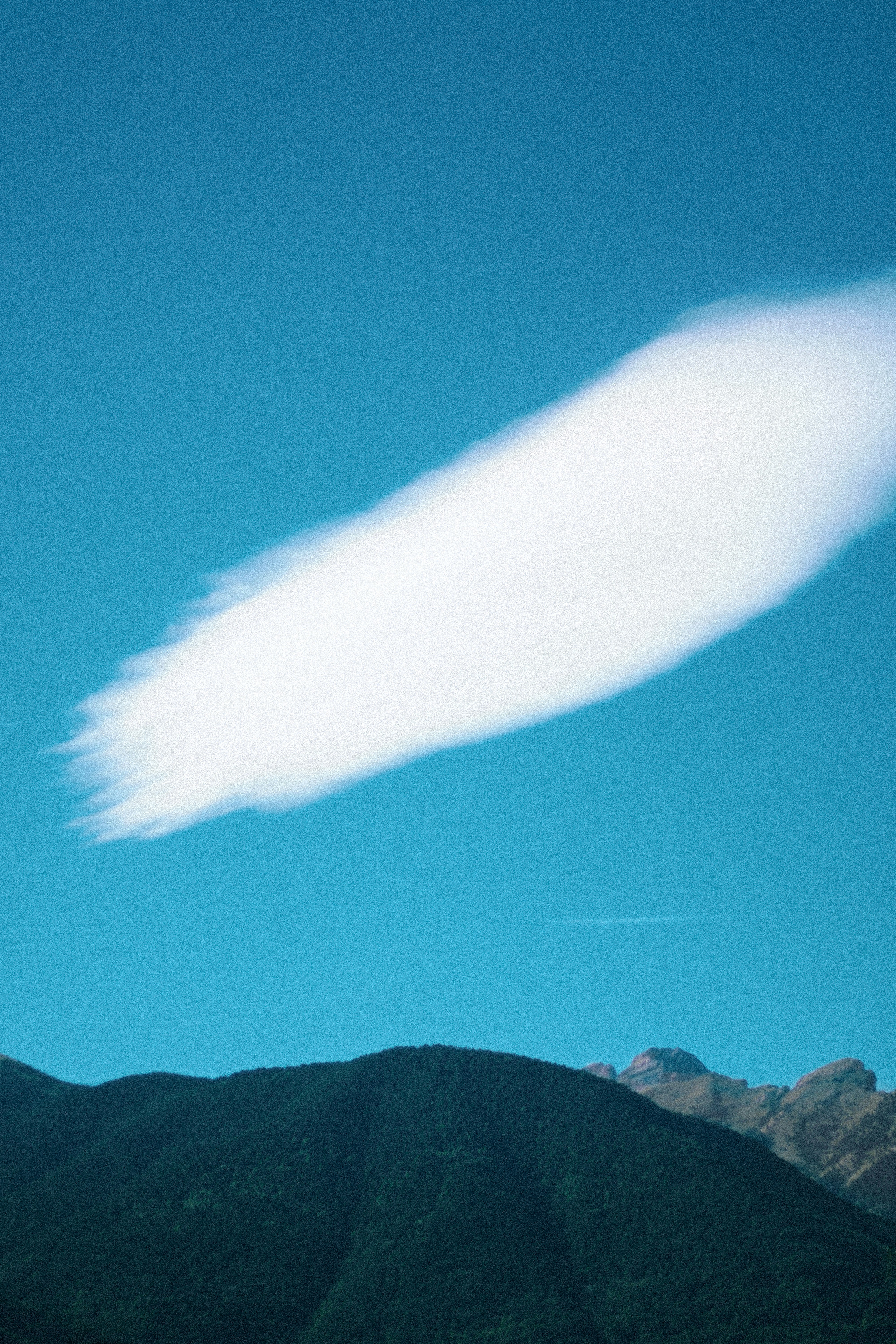 Azure Sky with a Lone Cloud Slice over Mountain Ridge
