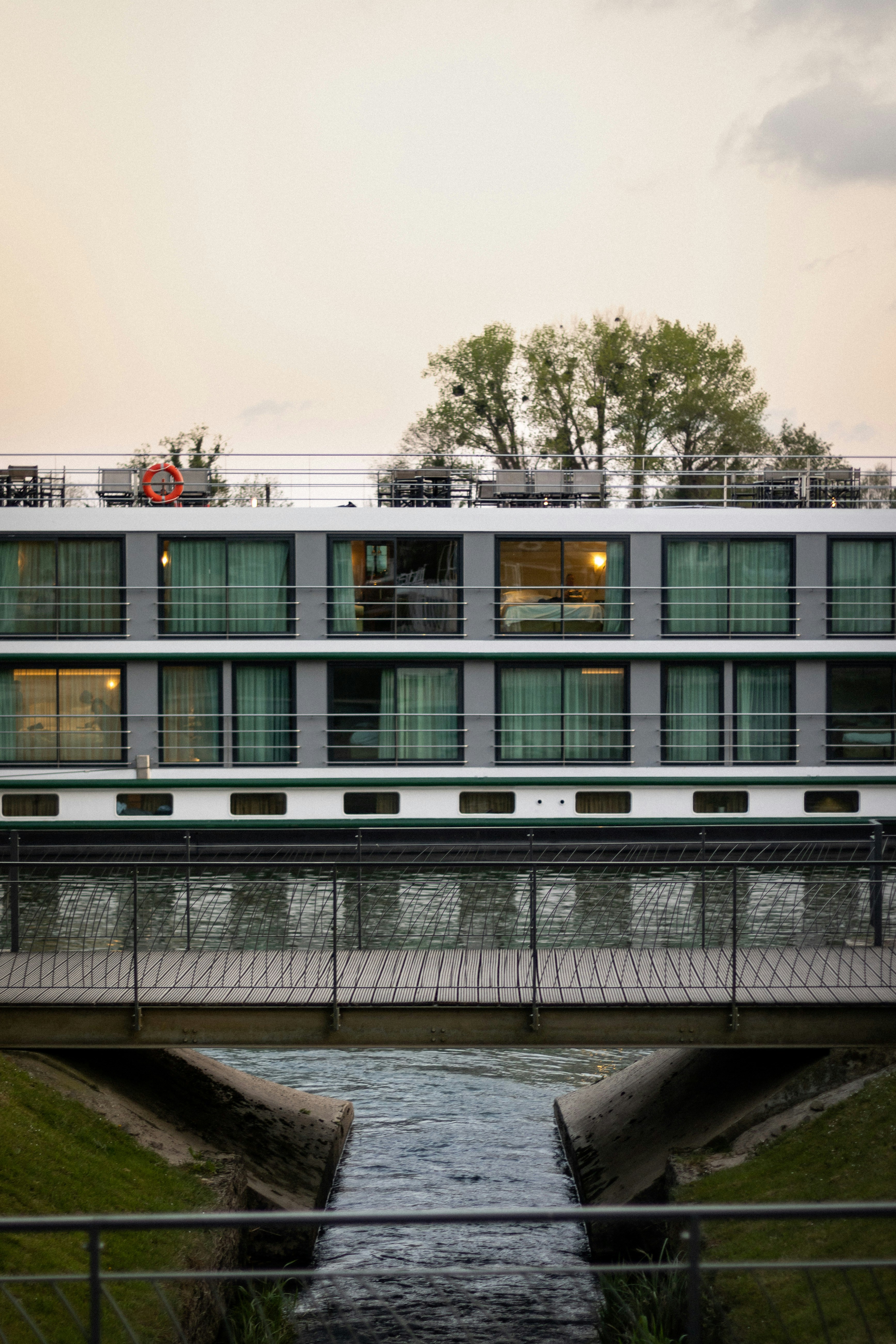Glass-Fronted Riverside Vessel Spanning a Narrow Canal