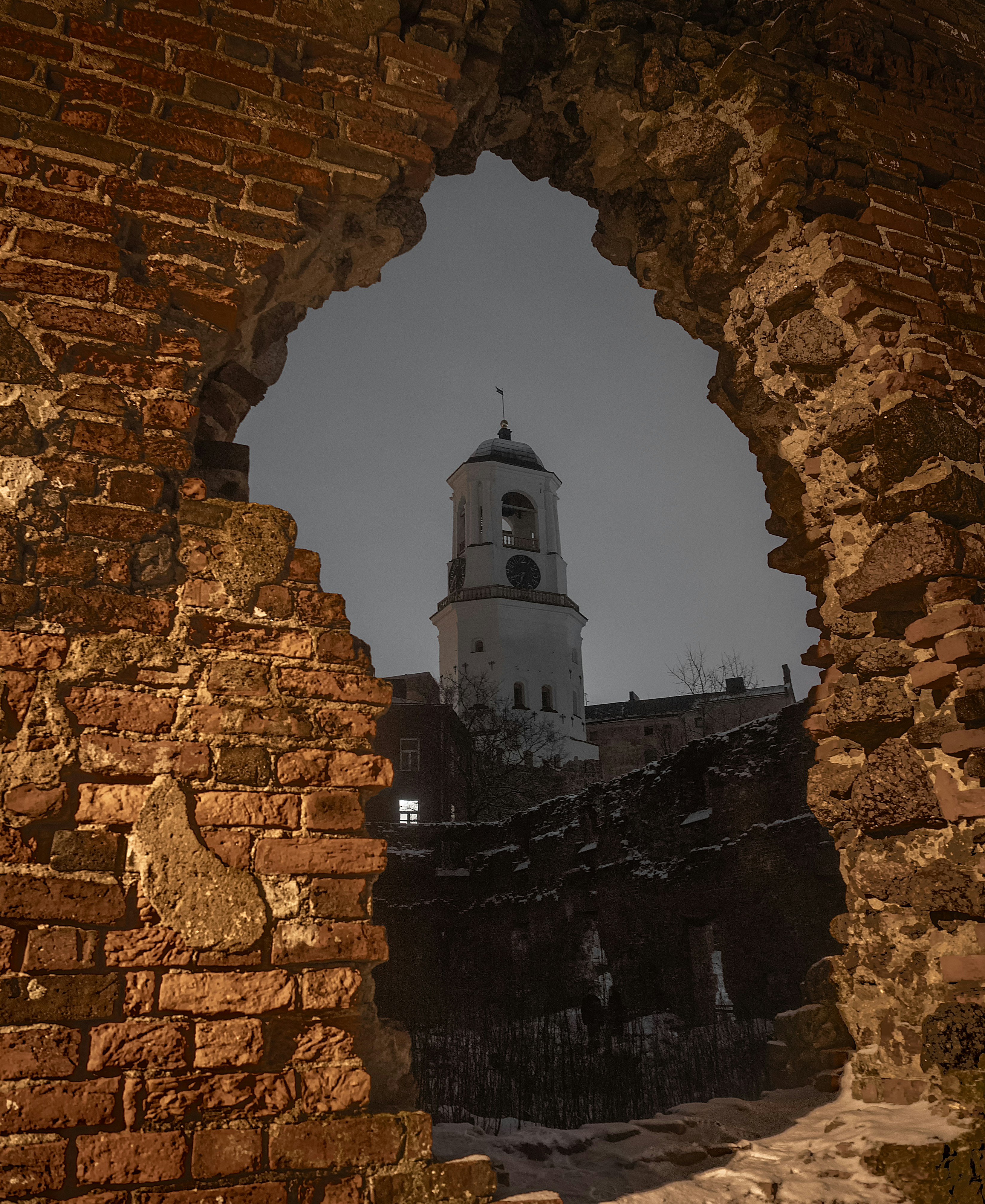 A stone archway with a building in the distance photo – Free Vyborg ...
