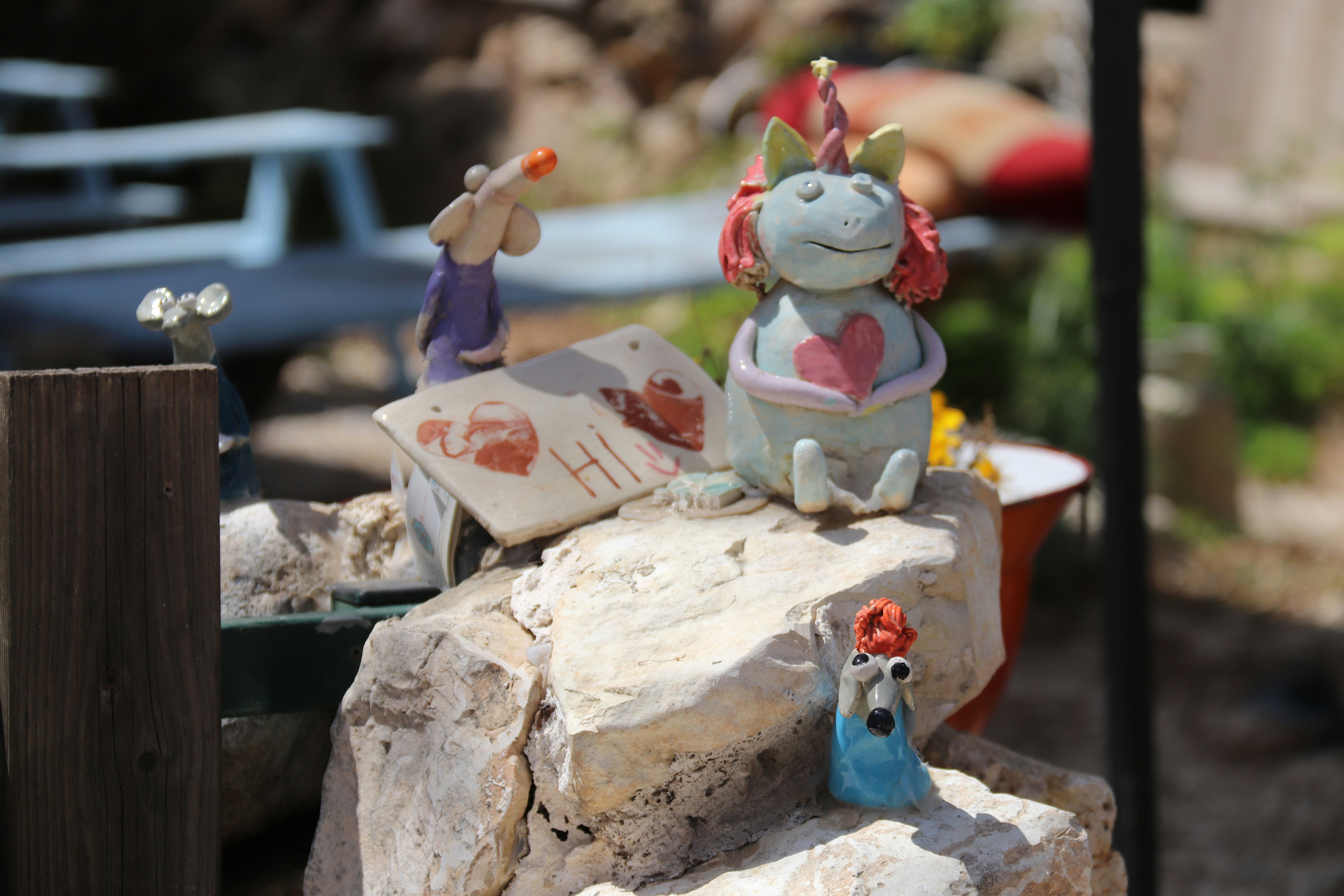 Whimsical hillside statues guard a sunlit garden corner