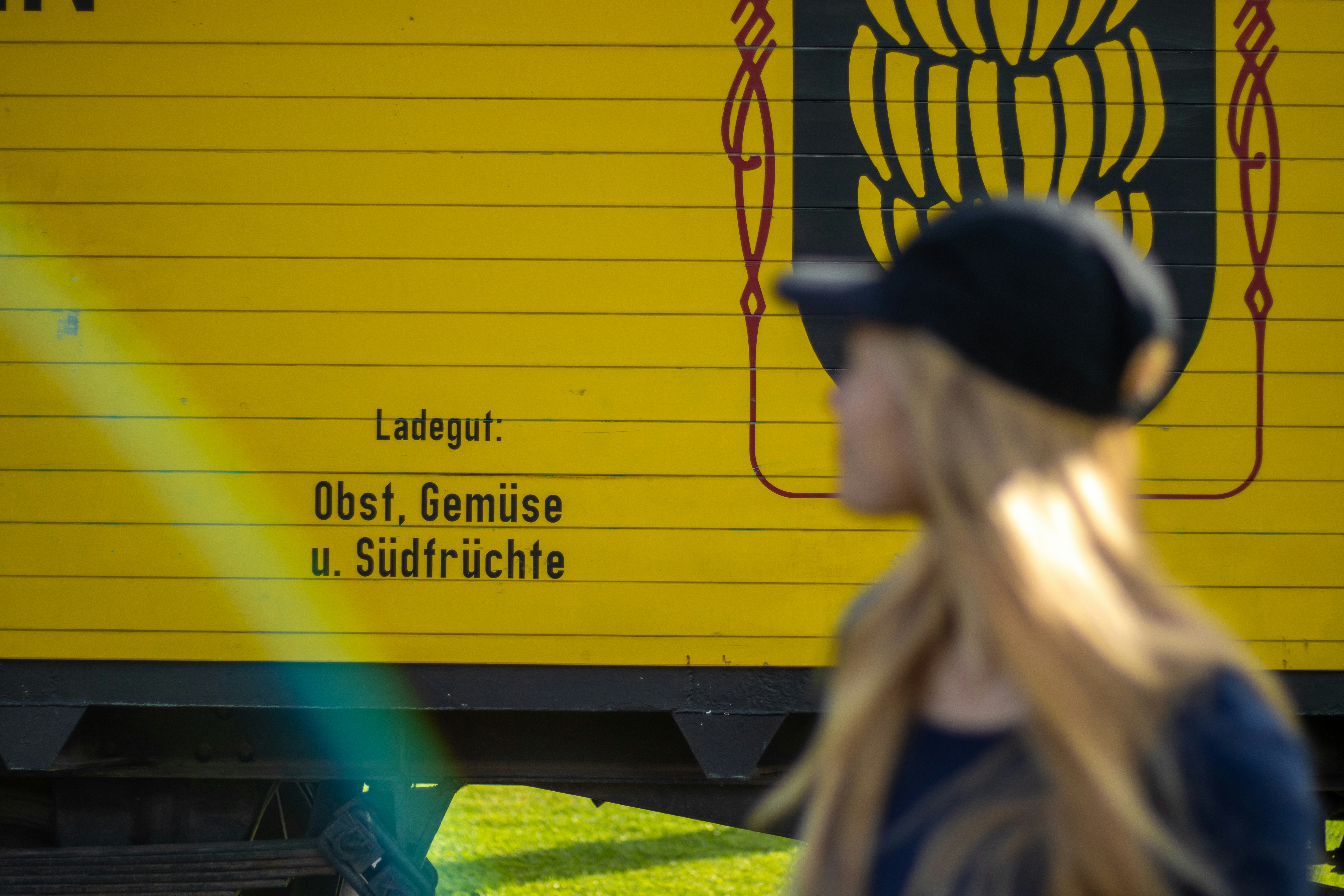 Laura in front of an old train transport box. Bright yellow, was used for bananas