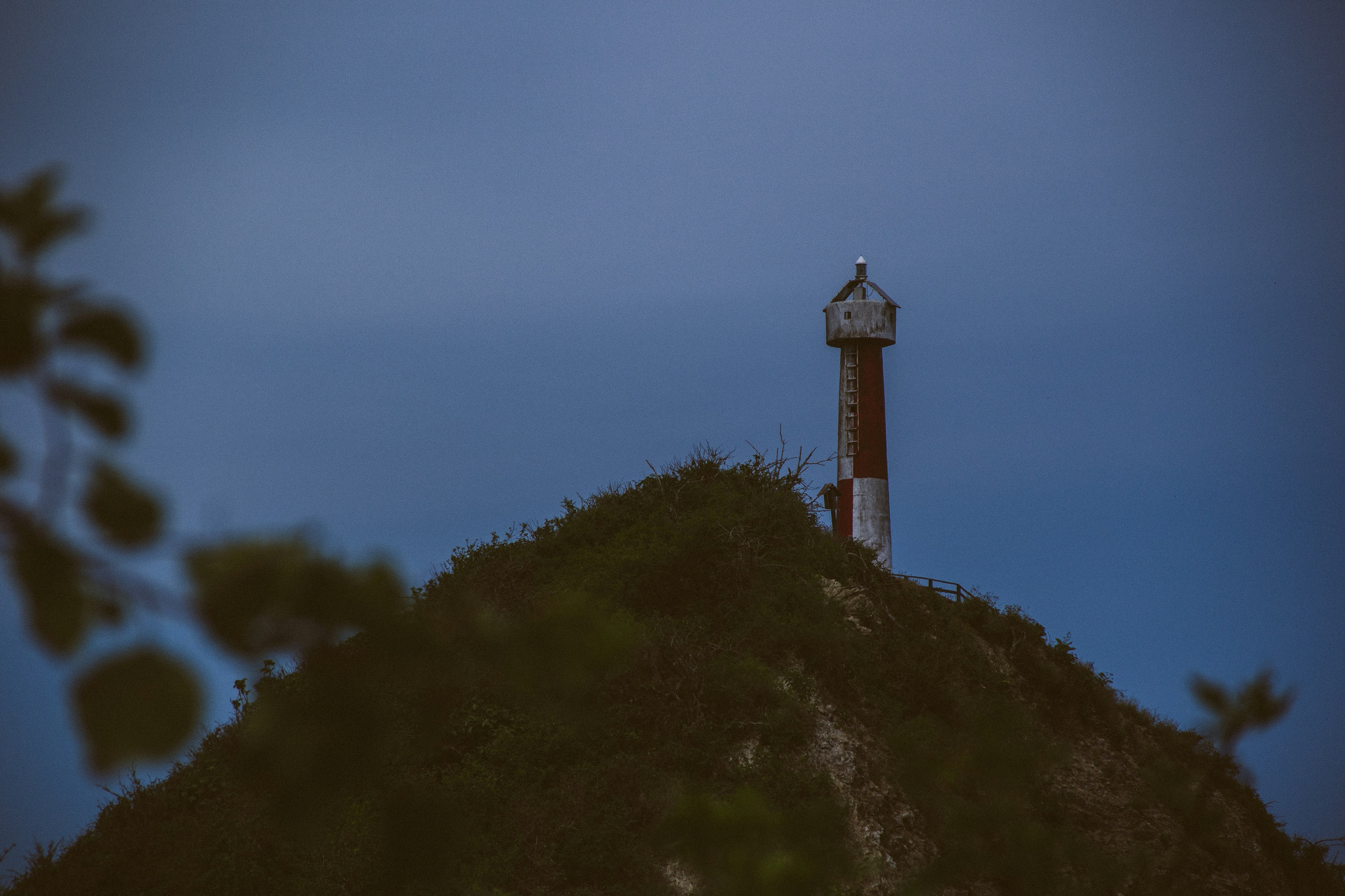 Dusk Beacon on the Hilltop: A Lone Lighthouse Against Evening Blues