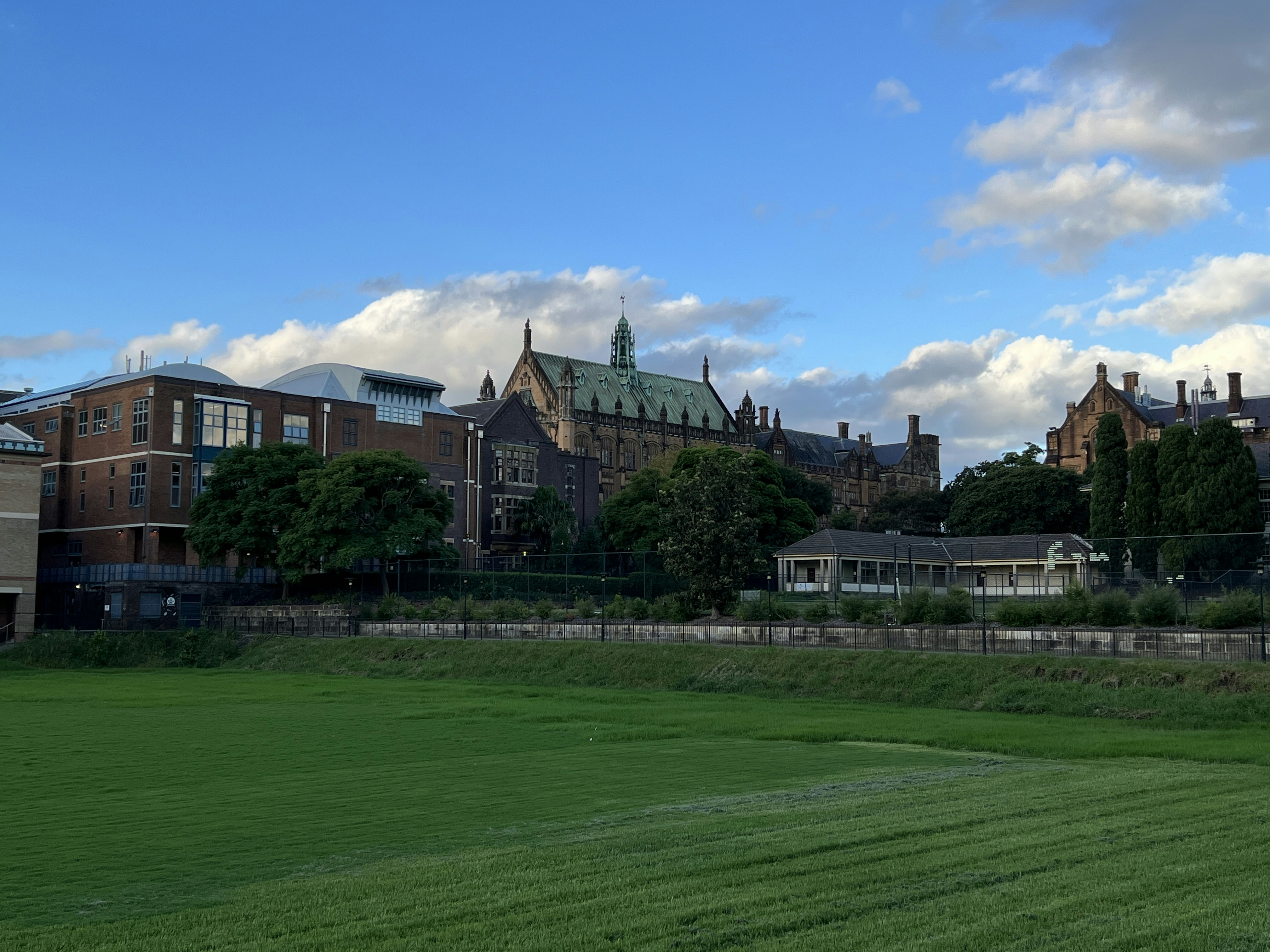 Copper Rooflines Rise Over a Lush Riverside Campus