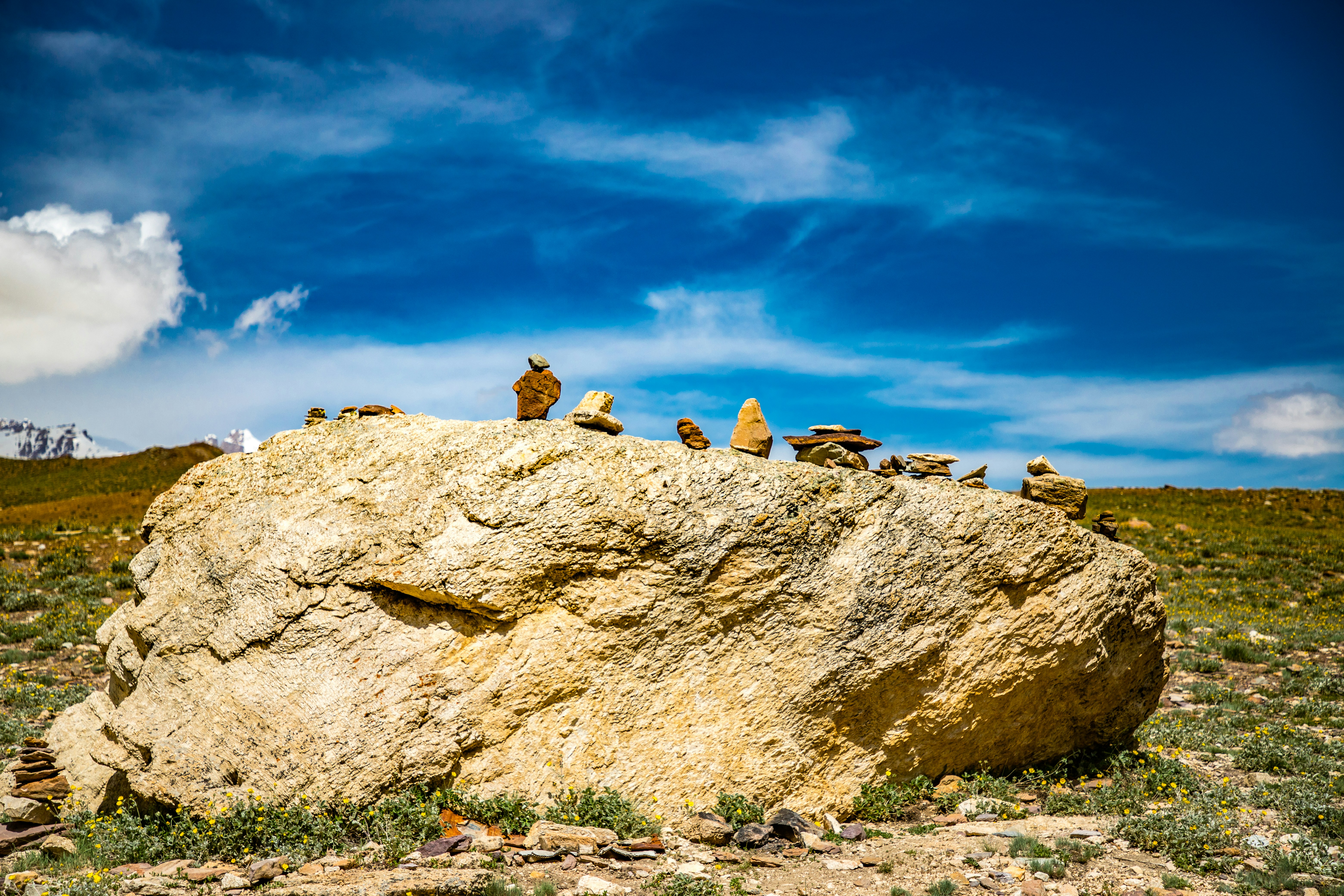 Balancing Acts: Cairns on a Weathered Boulder Under a Cerulean Desert Sky