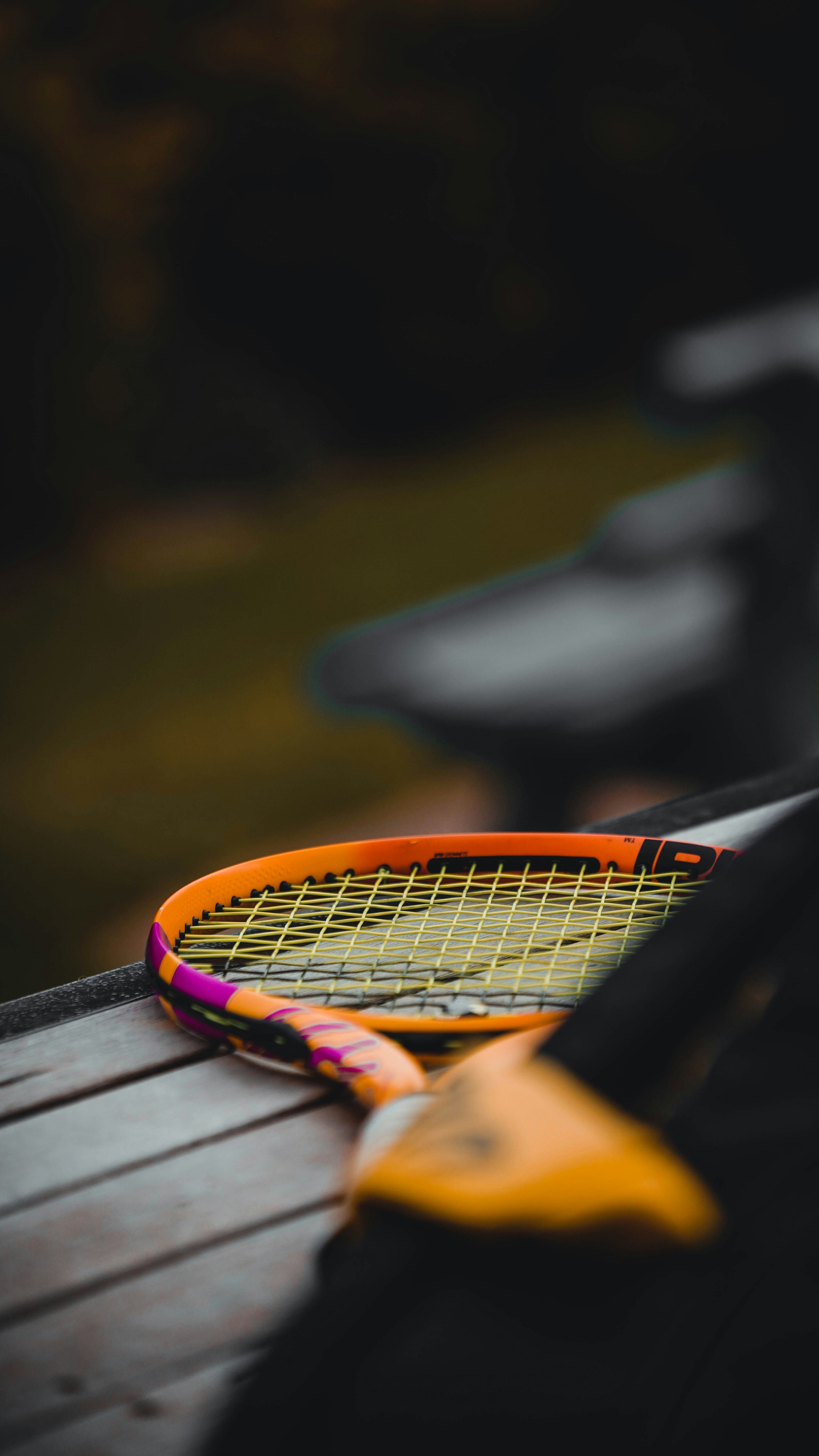 Tennis Rackets Resting on a Wooden Bench at Dusk