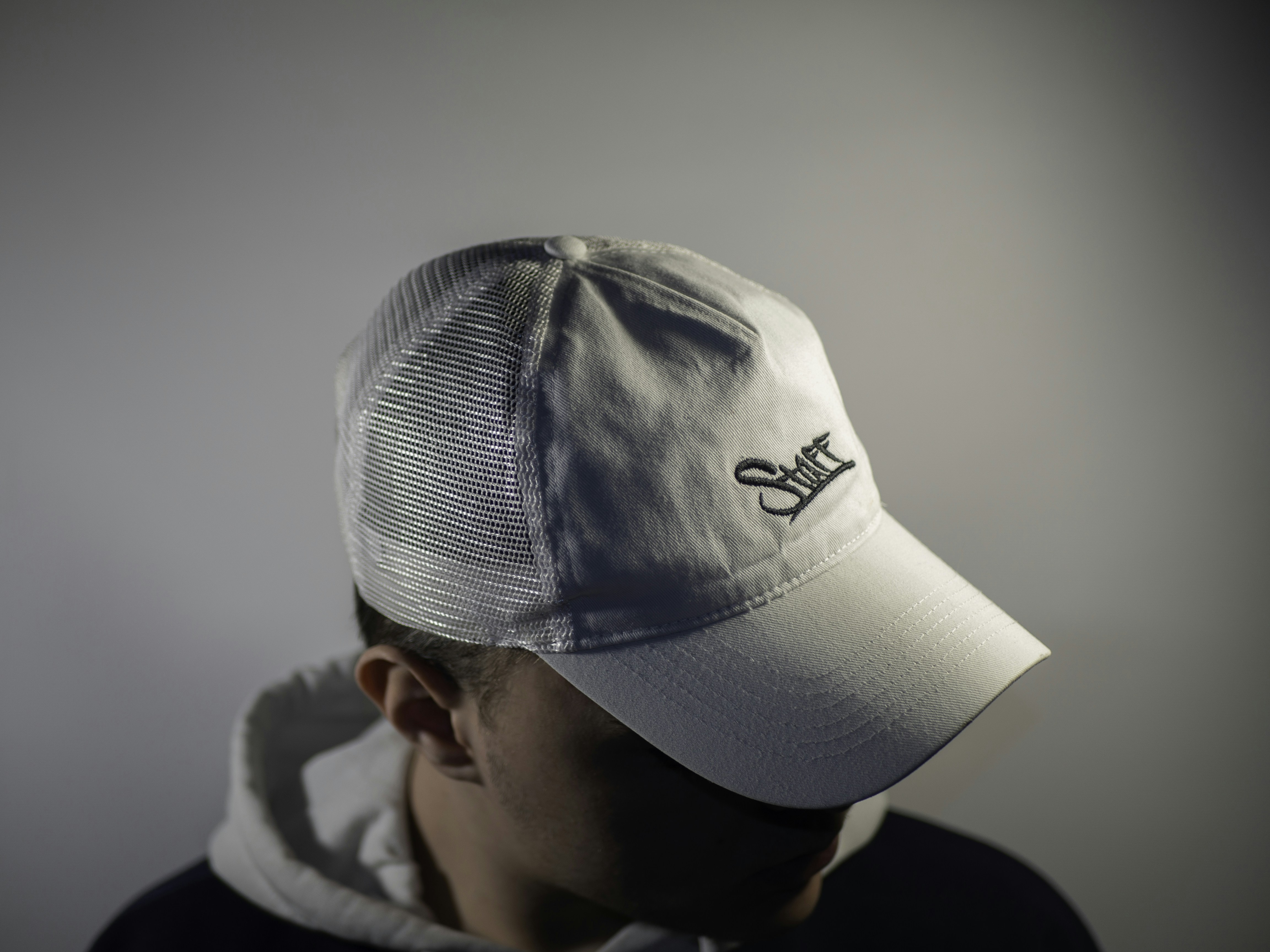Muted Spotlight on a White Cap: A Quiet Portrait of Texture and Light