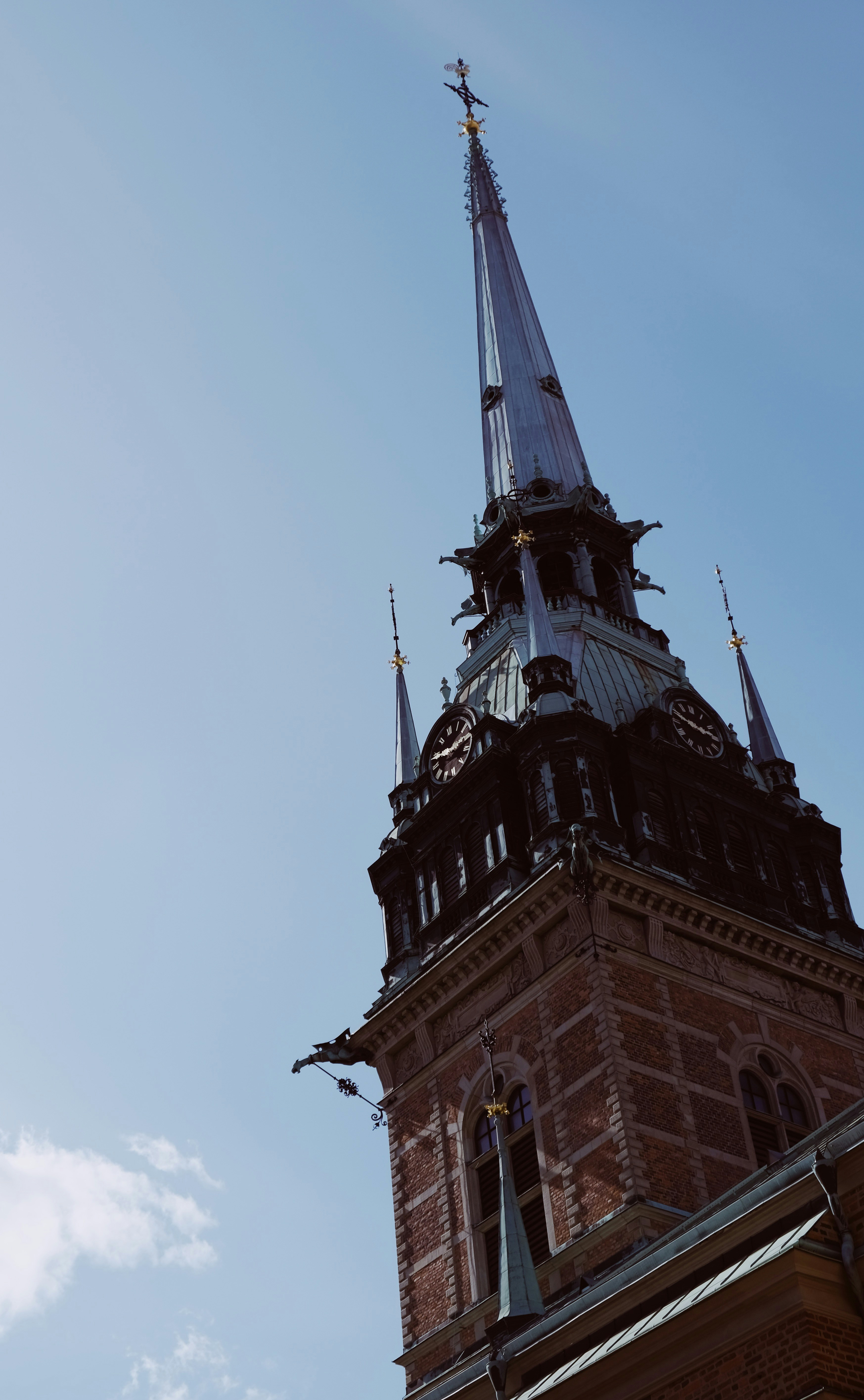 Towering church steeple adorned with intricate details against a clear blue sky.