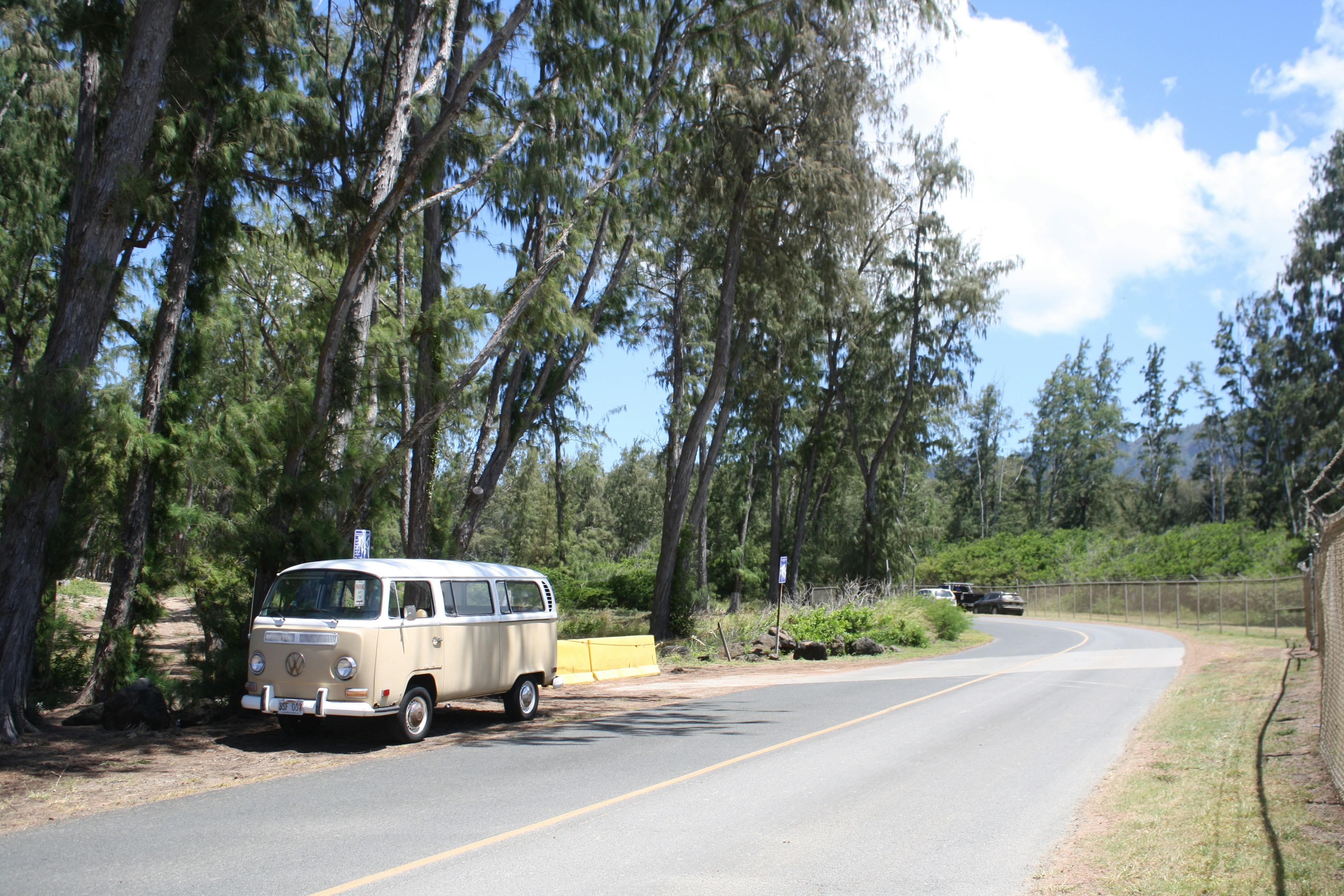 a van on a road with trees on the side